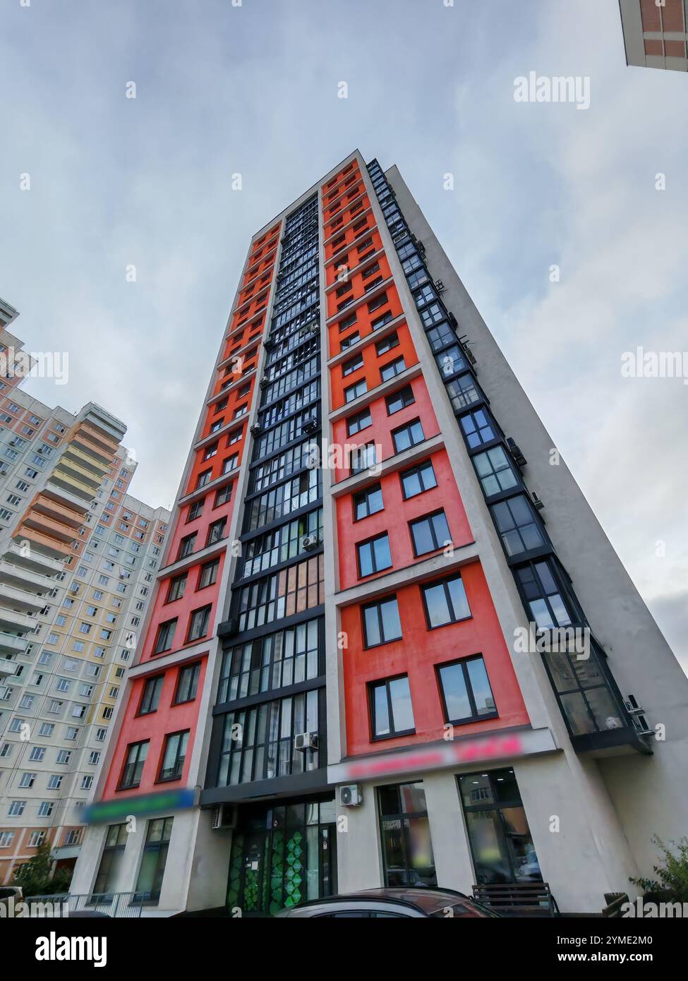 A tall apartment building with pastel-colored balconies and windows ...