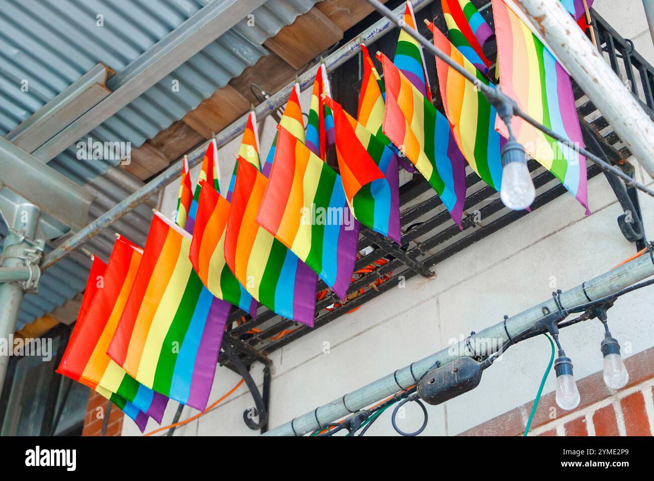 Multiple rainbow pride flags hanging from fire escape at Stonewall Inn ...