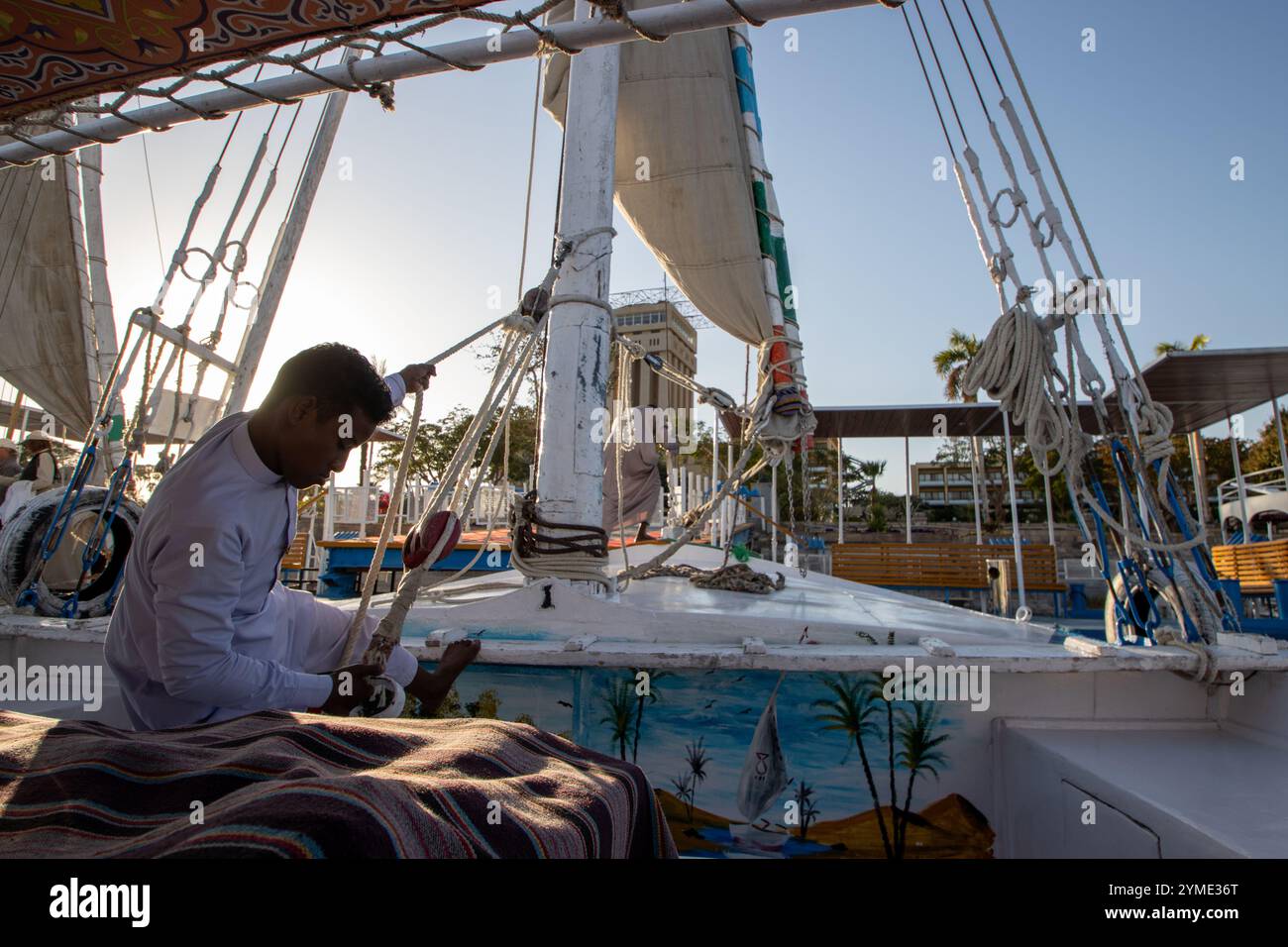 Man pulling on the sail on the boat Stock Photo - Alamy