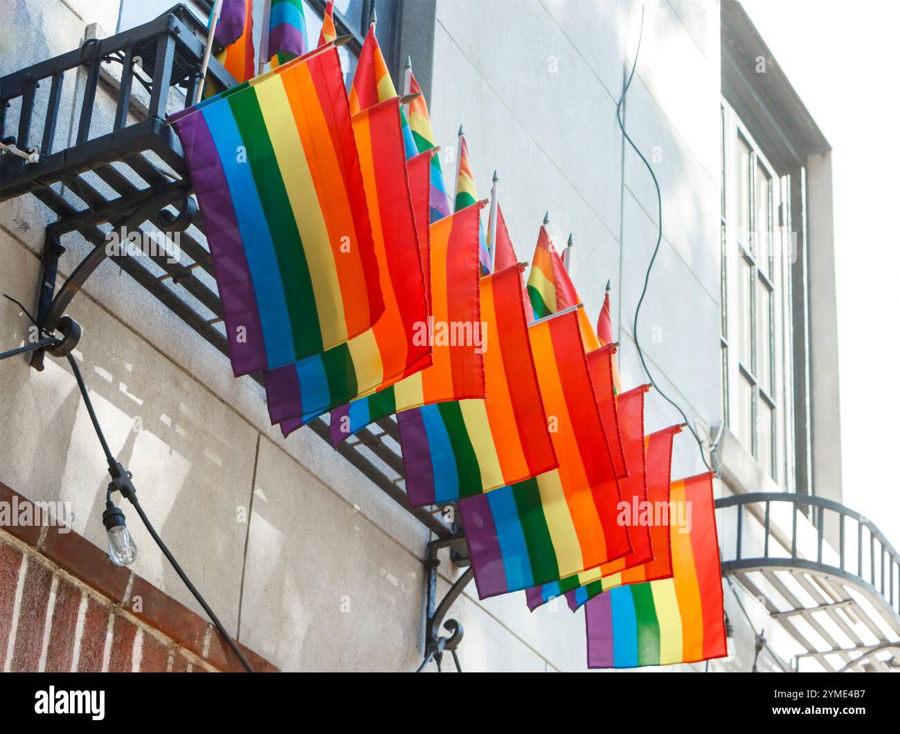 Multiple rainbow pride flags hanging from fire escape at Stonewall Inn ...