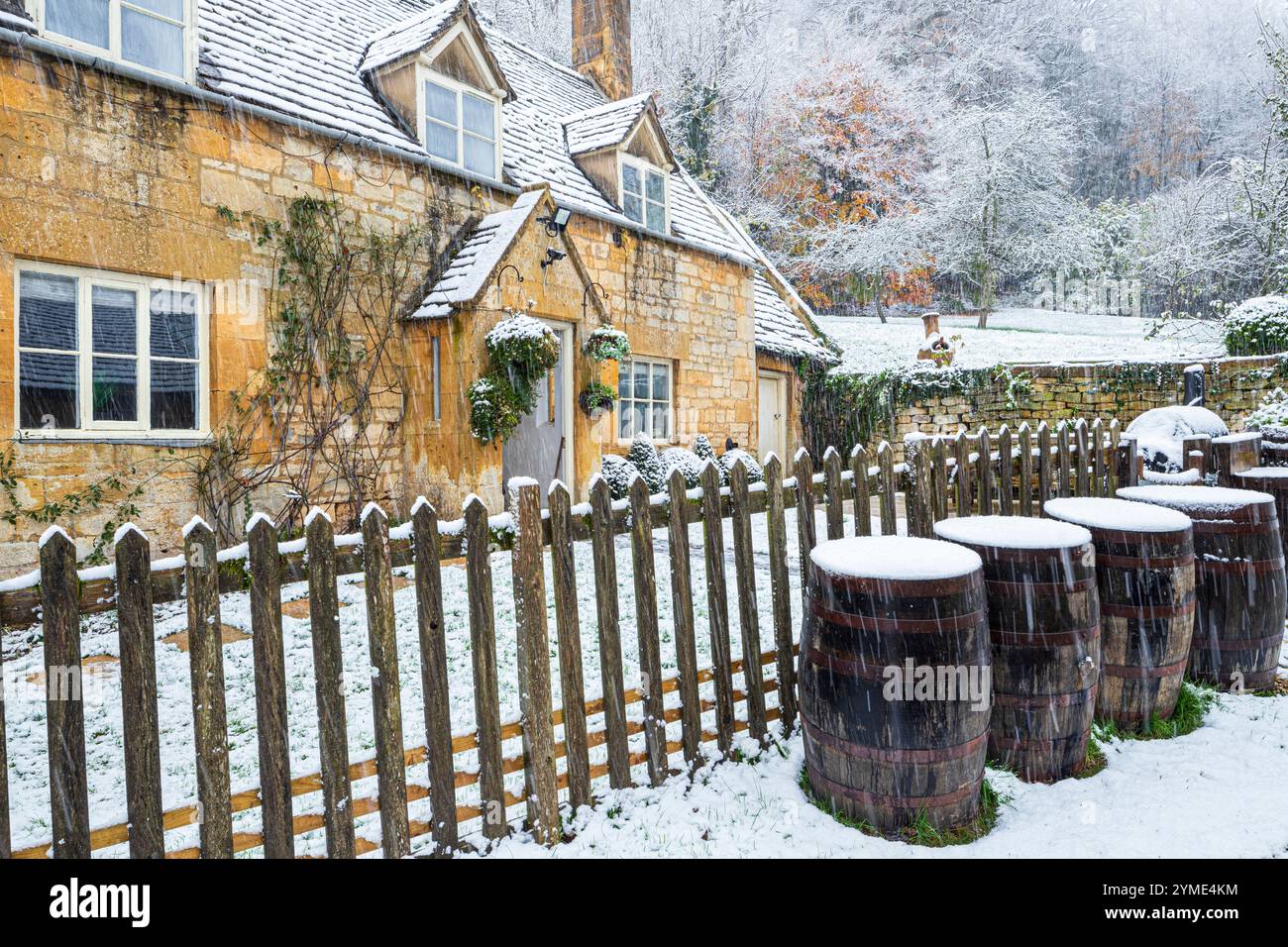 Early winter snow falling on a traditional stone cottage in the ...