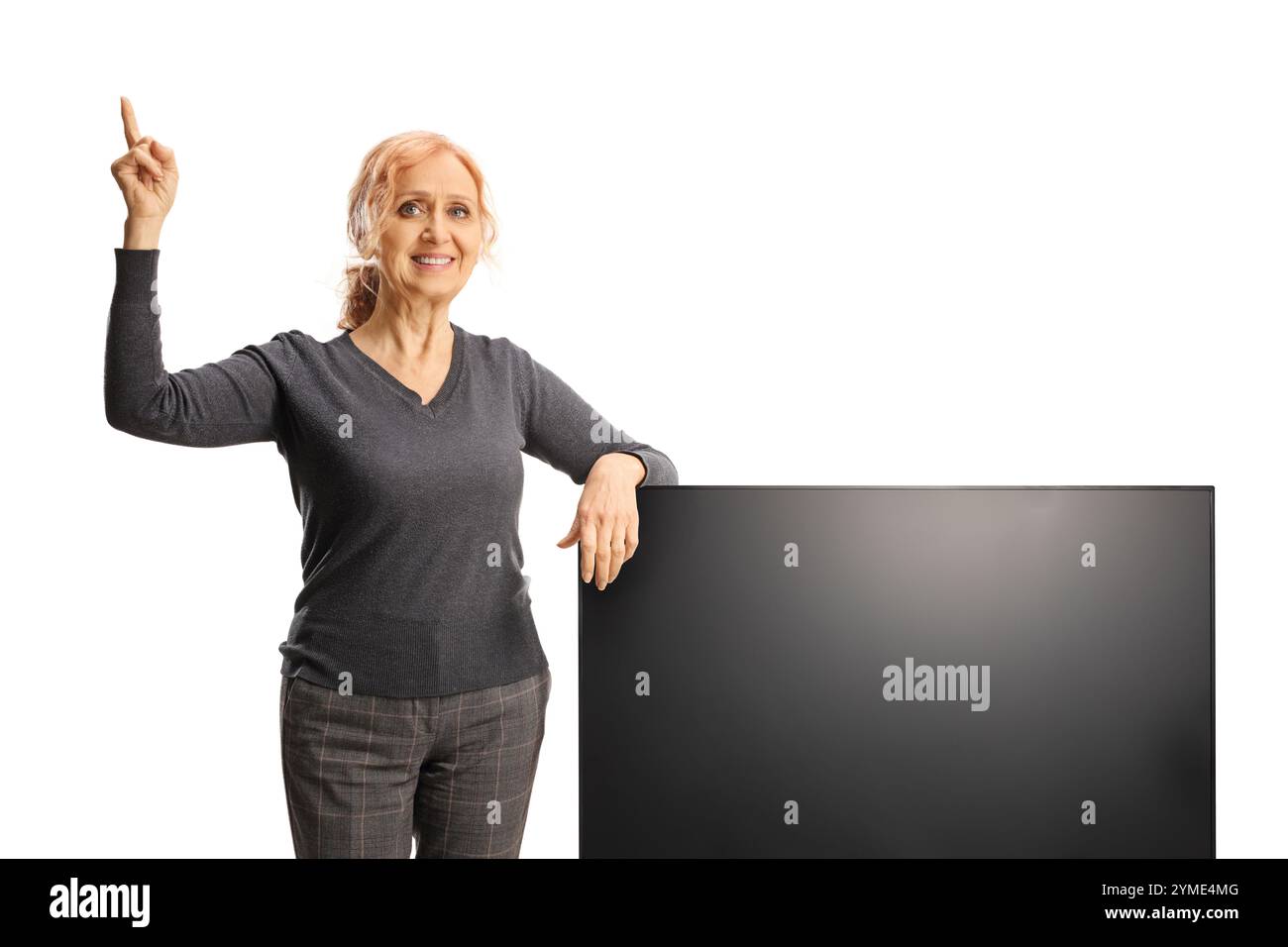 Woman pointing up and leaning on a flat tv screen isolated on white ...
