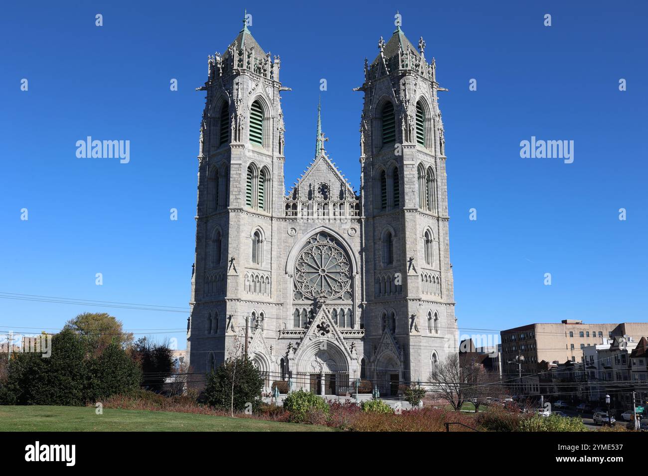 A gray stone basilica with two tall towers and a large rose window is ...