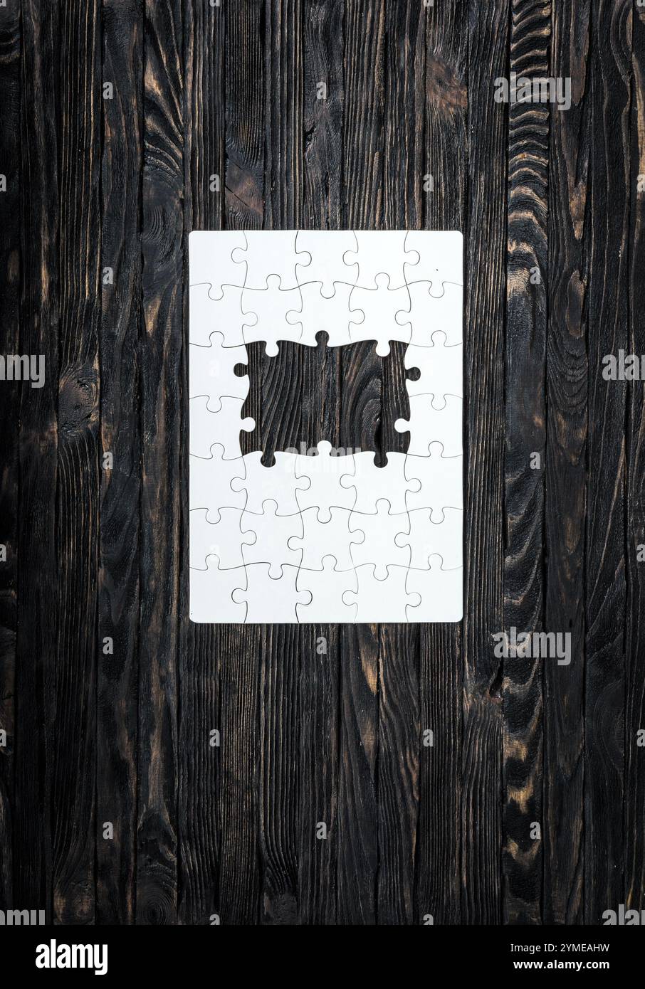 white started puzzle with uncompleted center on dark wooden background ...