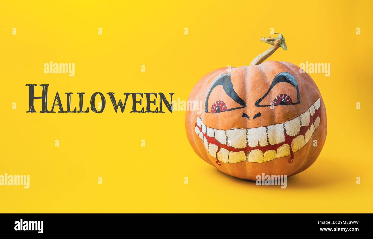 Pumpkin with a scary face painted on it is sitting on a yellow ...