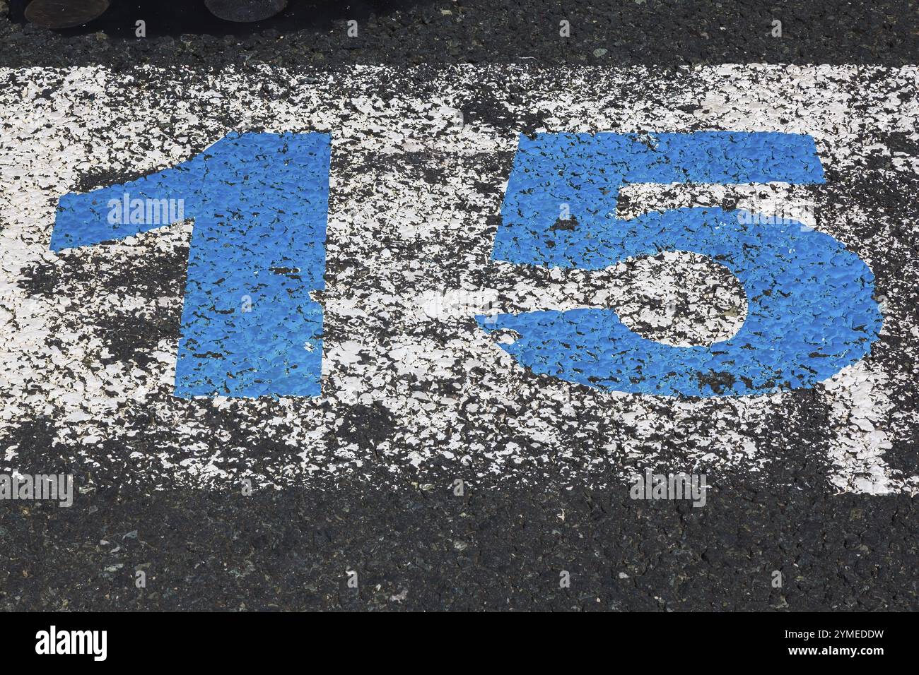 High angle view and close-up of big blue painted number 15 on white ...