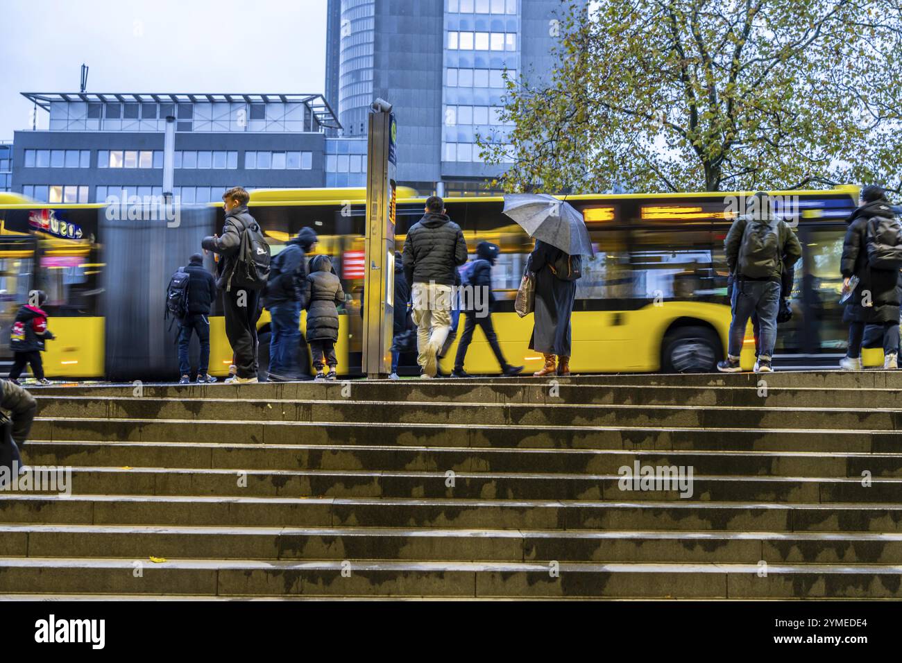 Autumn, rainy weather, bus stop at the central station, passengers ...