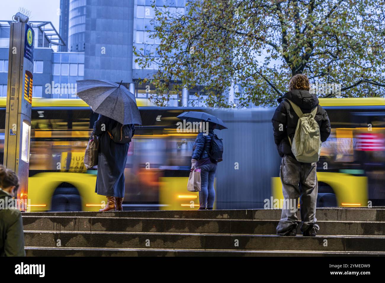 Autumn, rainy weather, bus stop at the central station, passengers ...