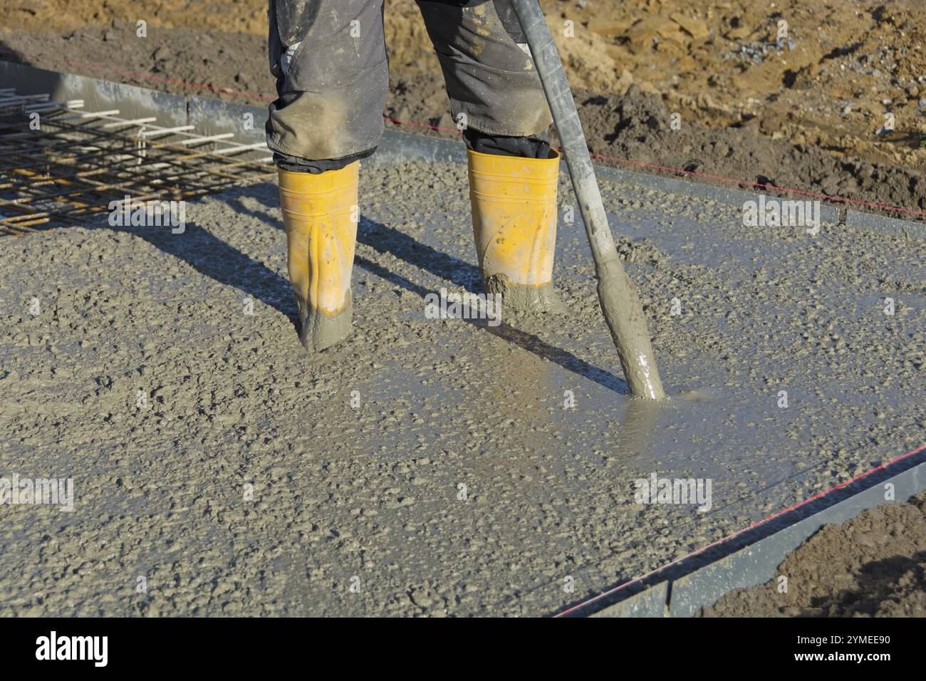 Fresh concrete of a floor slab is compacted by a worker Stock Photo - Alamy