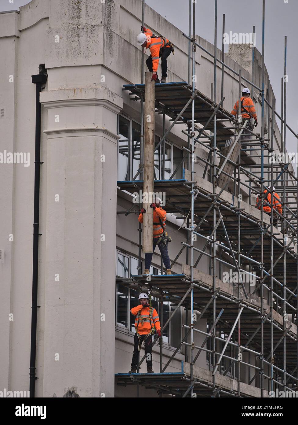 Scaffold being erected by a team of scaffolders in orange hi-vis and ...