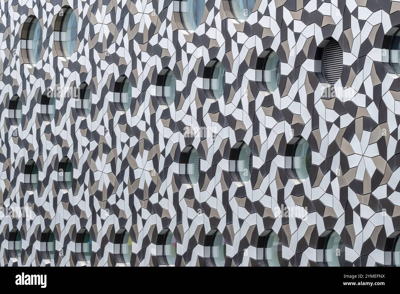 Facade with geometric patterns and circular windows creating a modern ...