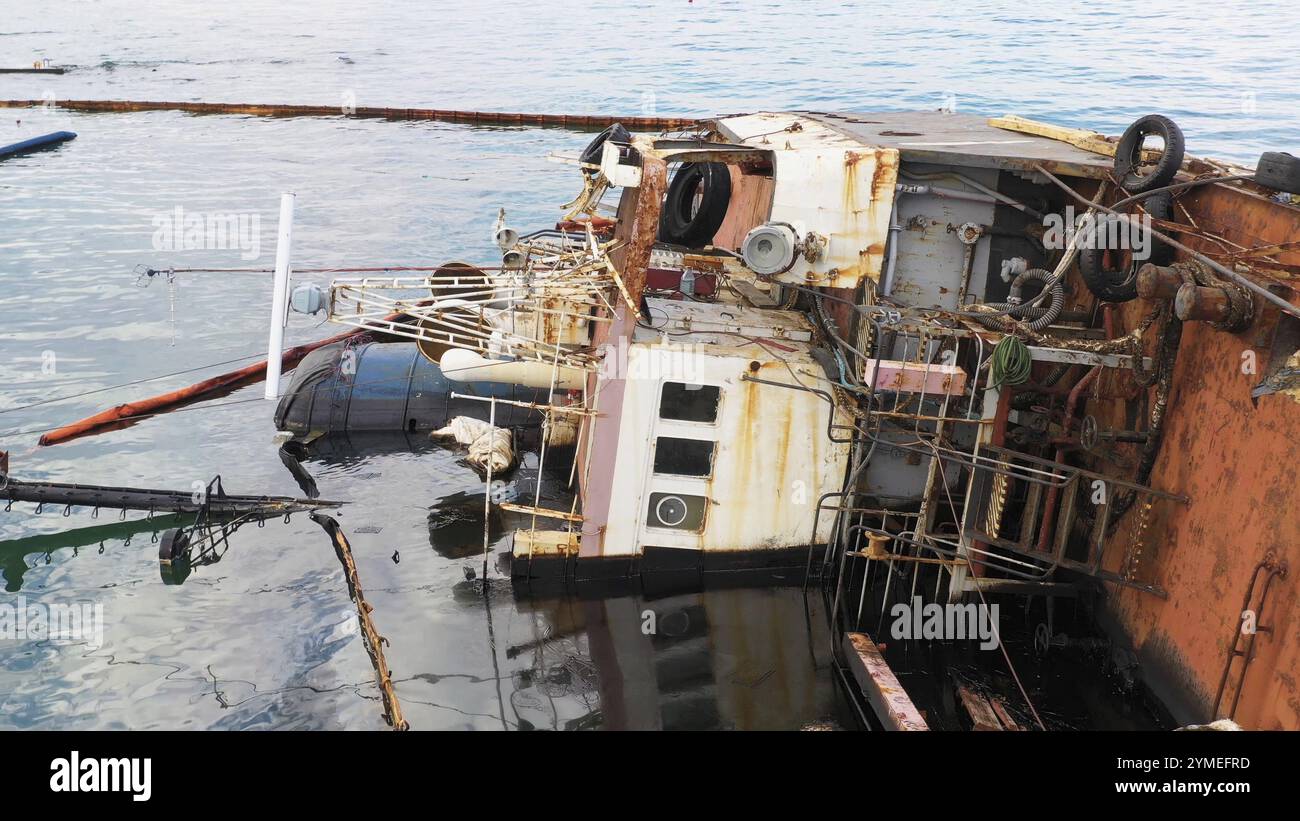 Overturned oil tanker ship in the shallow water. Close up sunken ...