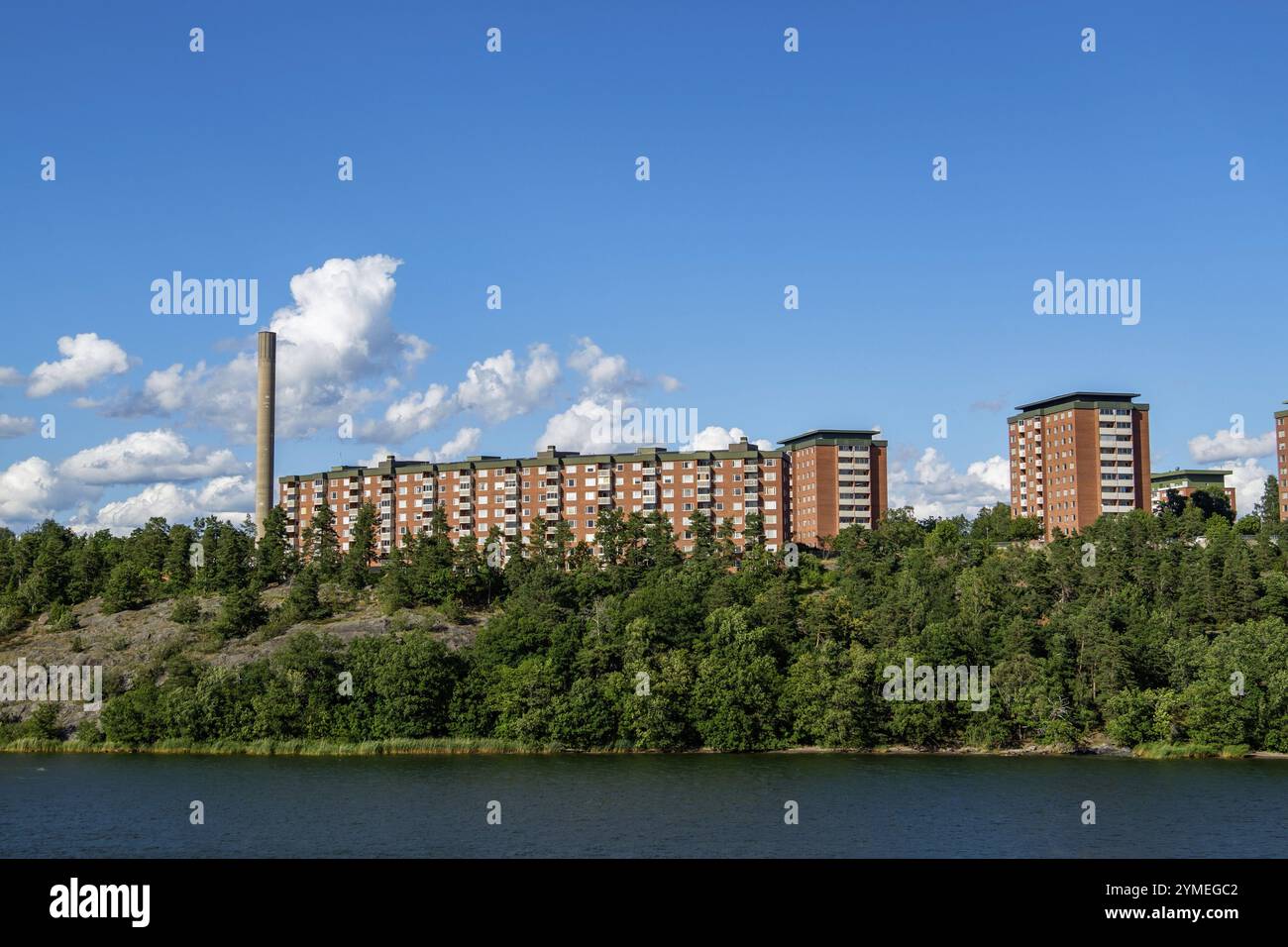 Red brick tower blocks on a riverbank surrounded by forest, archipelago ...
