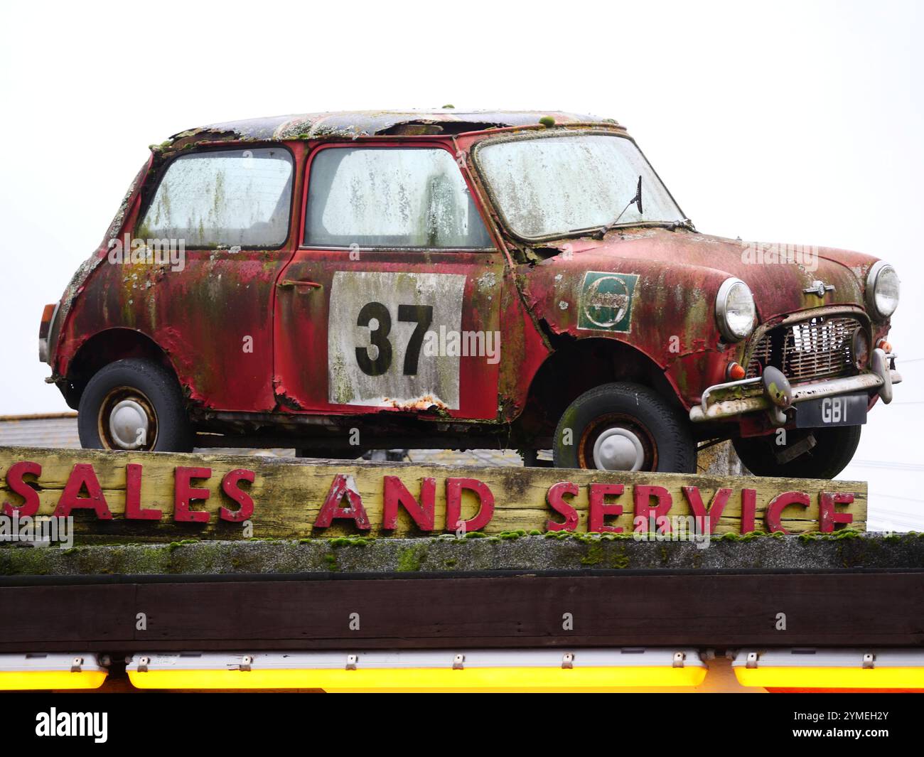 Old original classic Austin mini car rusting away mounted on a roof ...