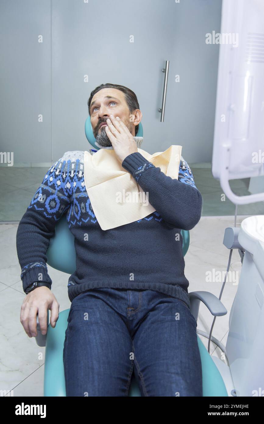Adult male in dental chair. Man having toothache. Tooth decay symptoms ...