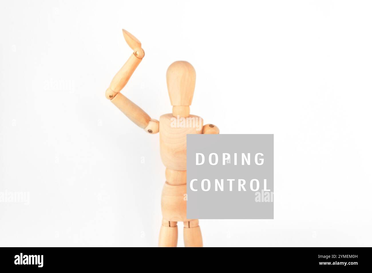 Wooden figure is holding a sign that says Doping Control. The image ...
