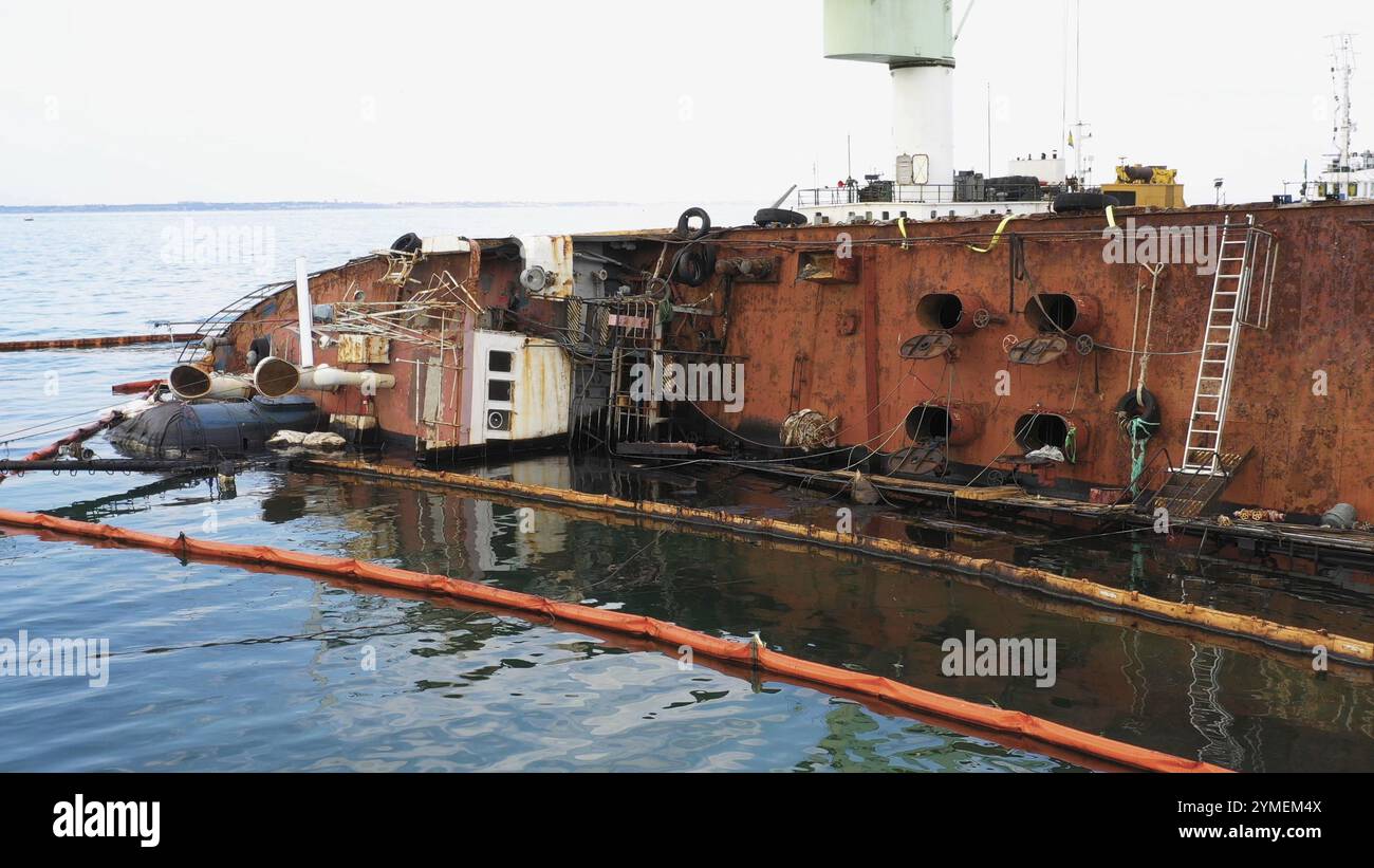 Close up of overturned oil tanker lying on its edge on the shallow ...