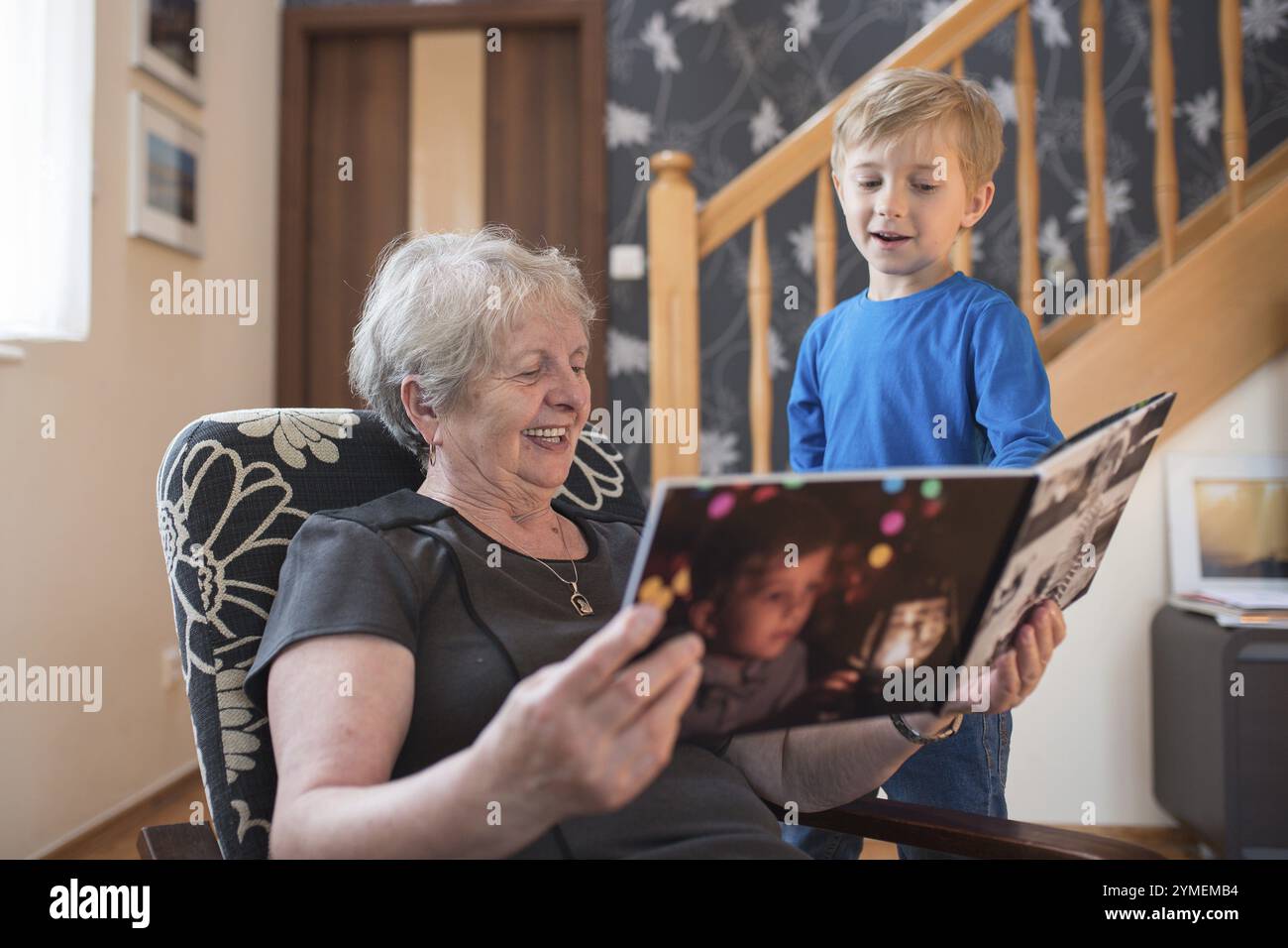 Grandmother and grandson watching photo album with the grandson ...