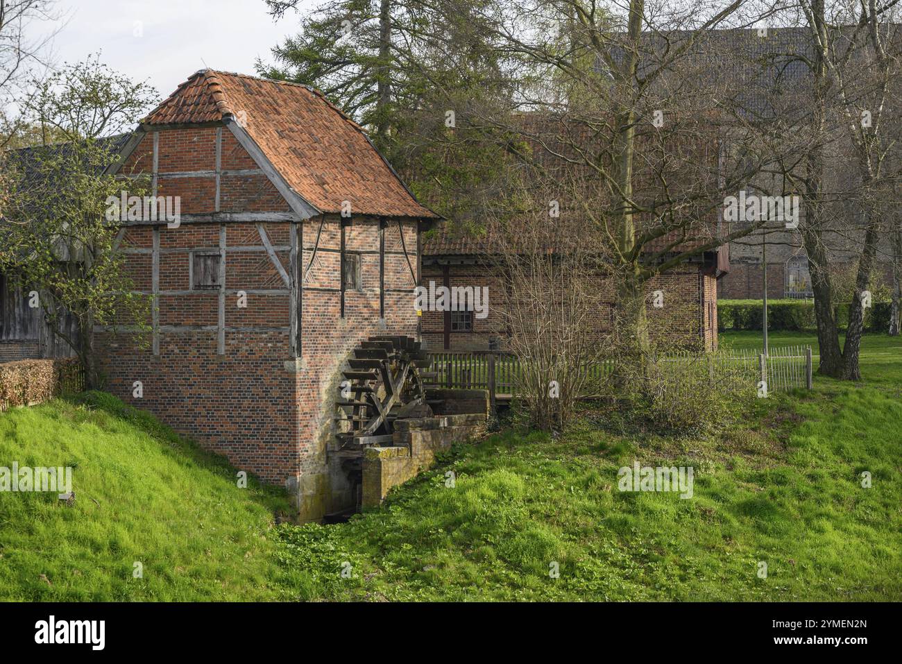 Historic watermill made of red brick with timber framework, surrounded ...