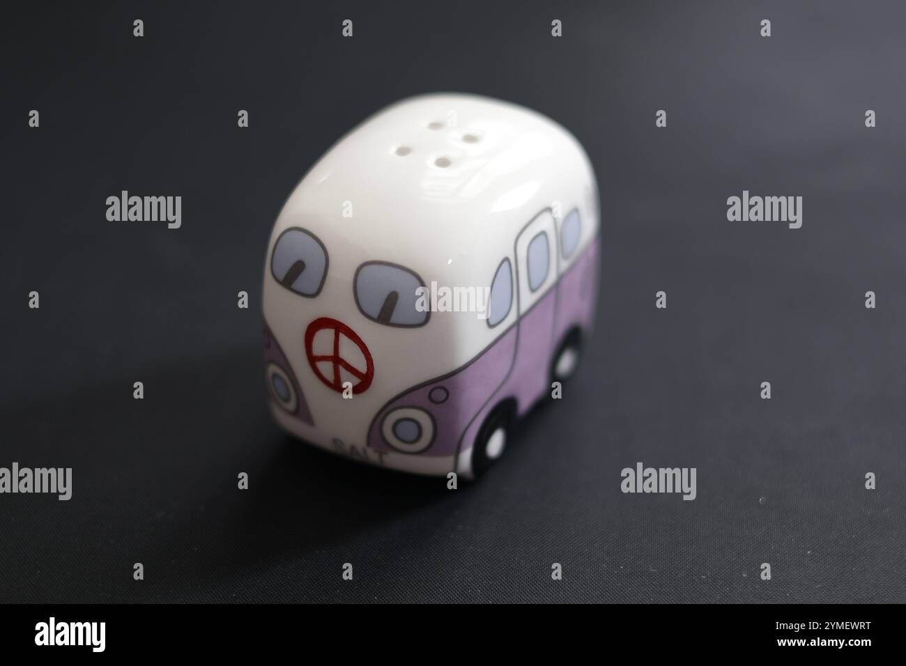 A charming ceramic salt shaker designed in the shape of a purple bus ...