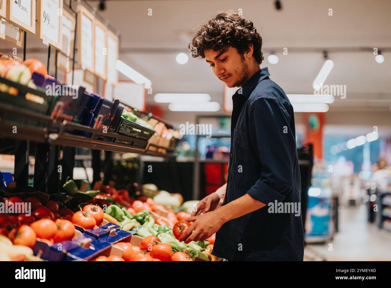 Young man selecting fresh produce in a grocery store Stock Photo - Alamy