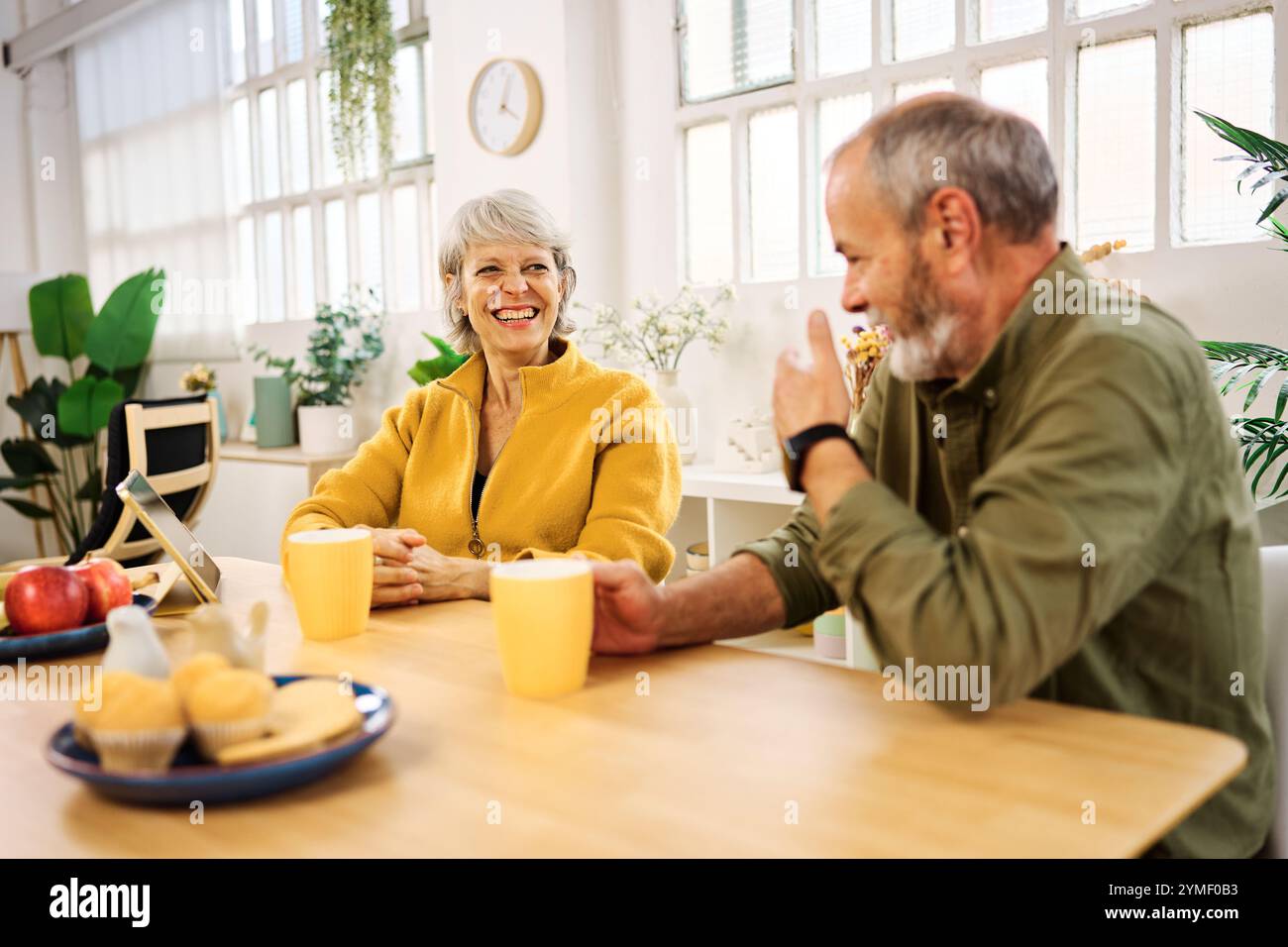 Senior couple enjoying breakfast and conversation at home Stock Photo ...