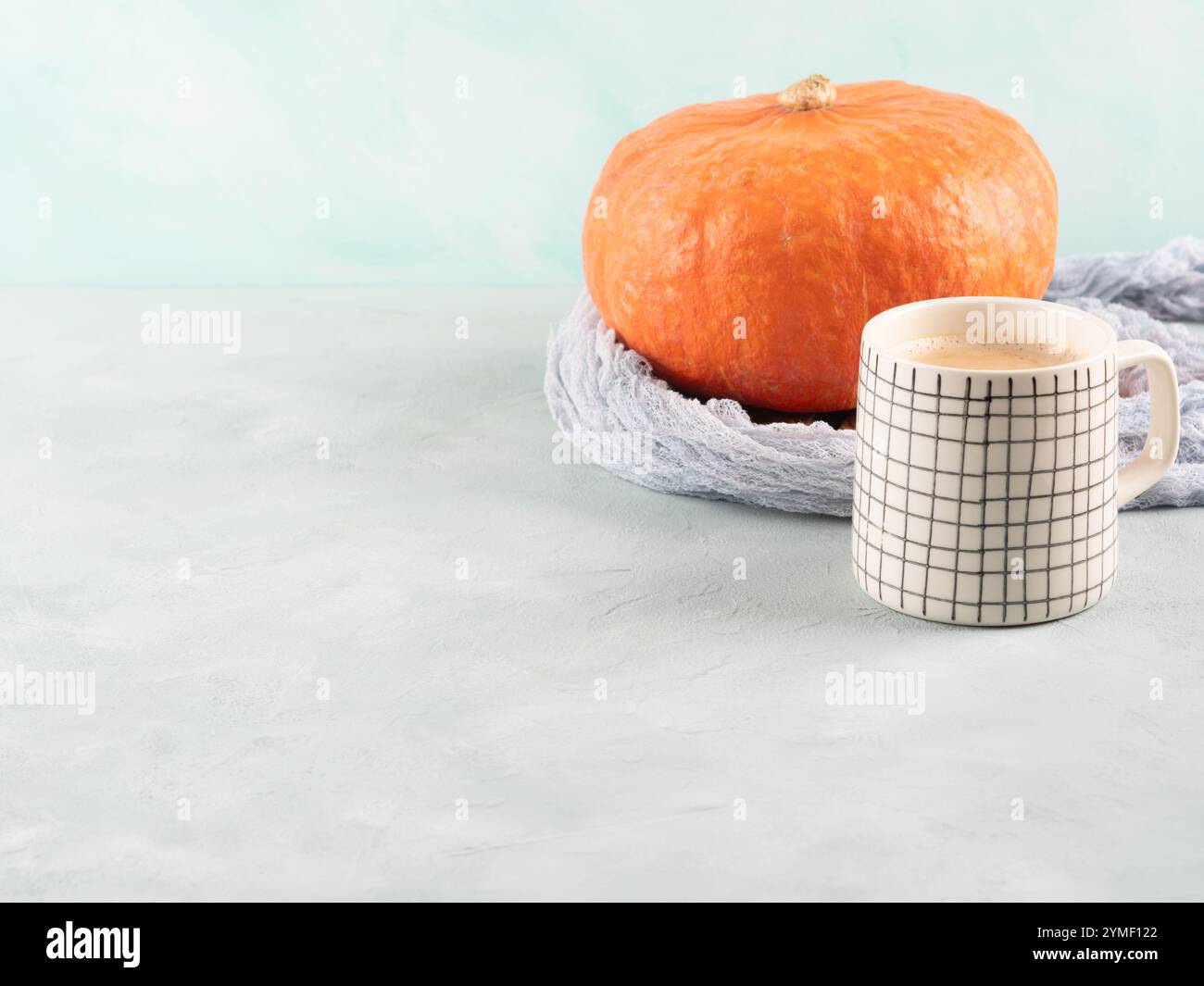 Pumpkin spiced latte coffee on turquoise background with orange squash ...