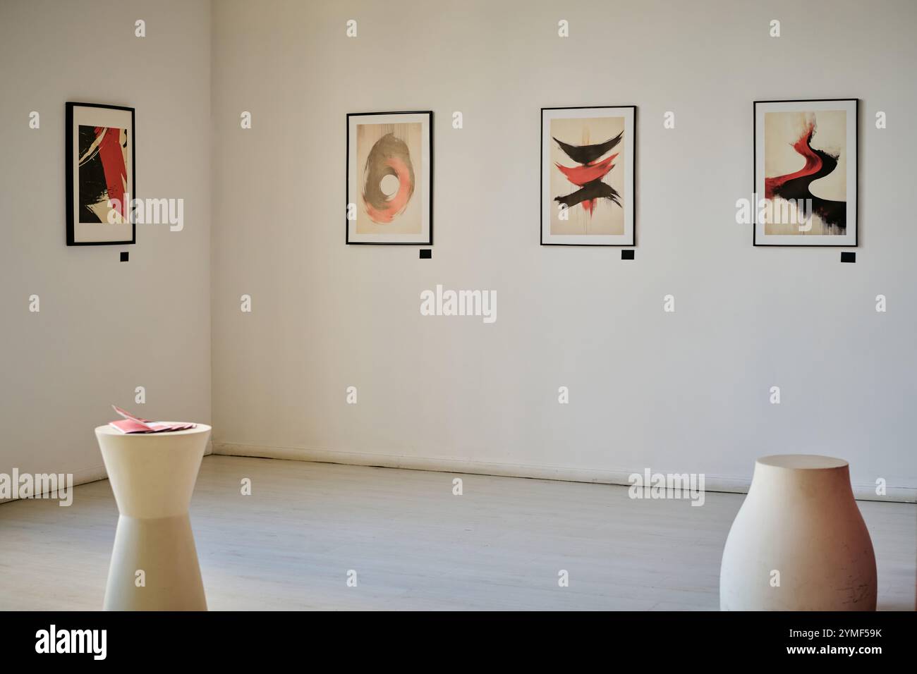 Modern abstract art paintings displayed in minimalist gallery with ...