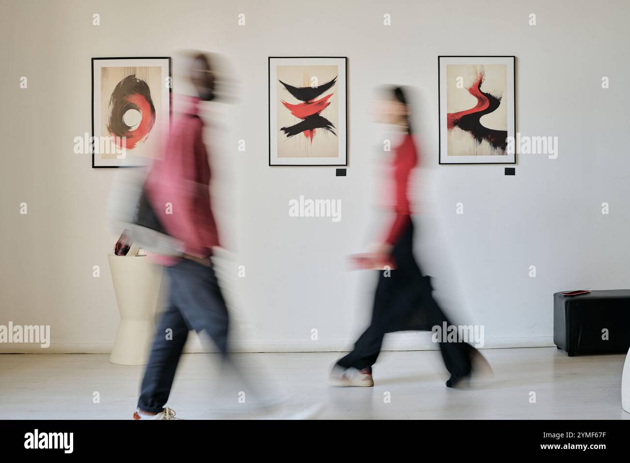 People walking through an art gallery, admiring contemporary paintings ...