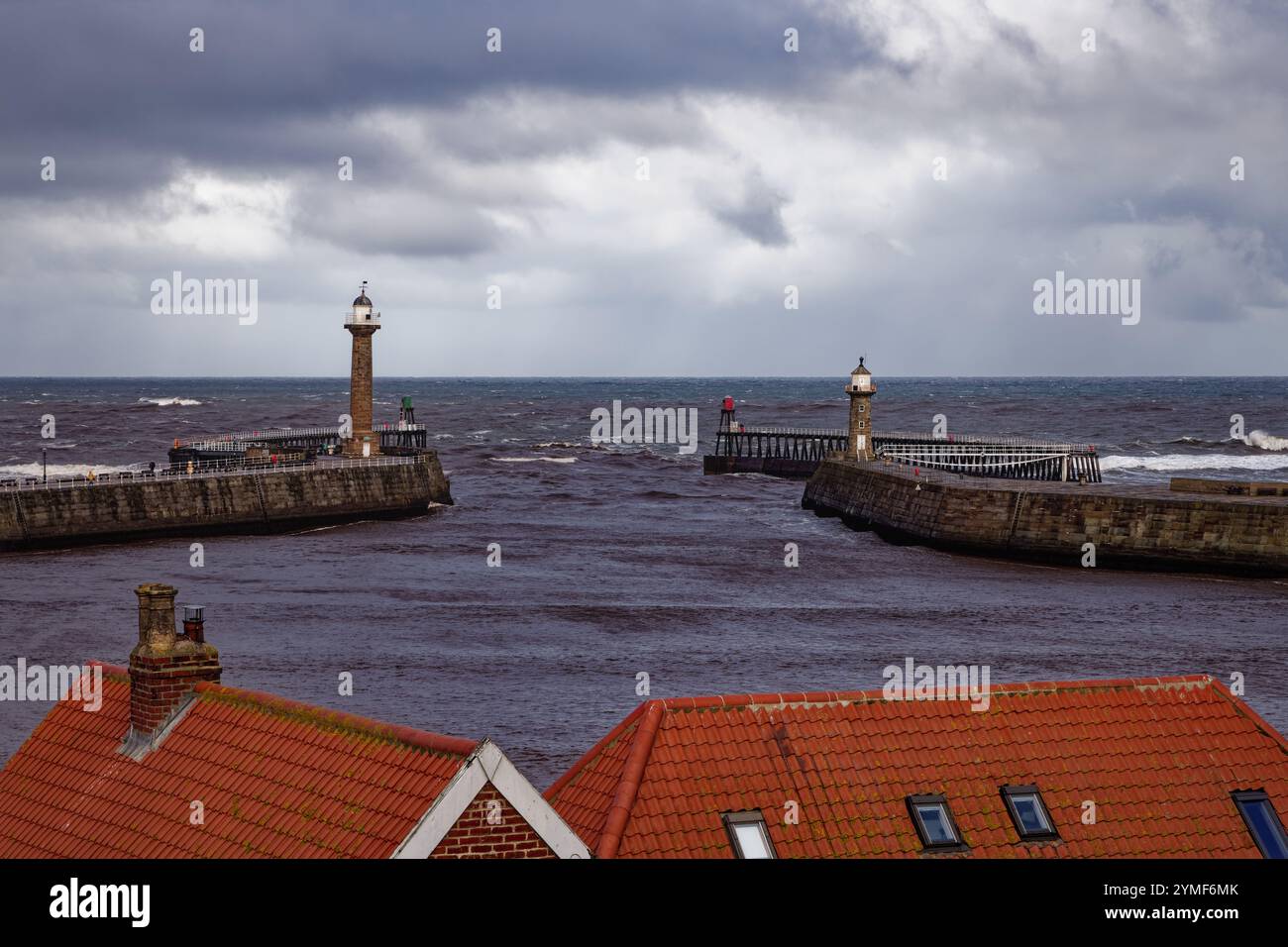 Storm clouds gather over the twin lighthouses of Whitby Harbour, North ...