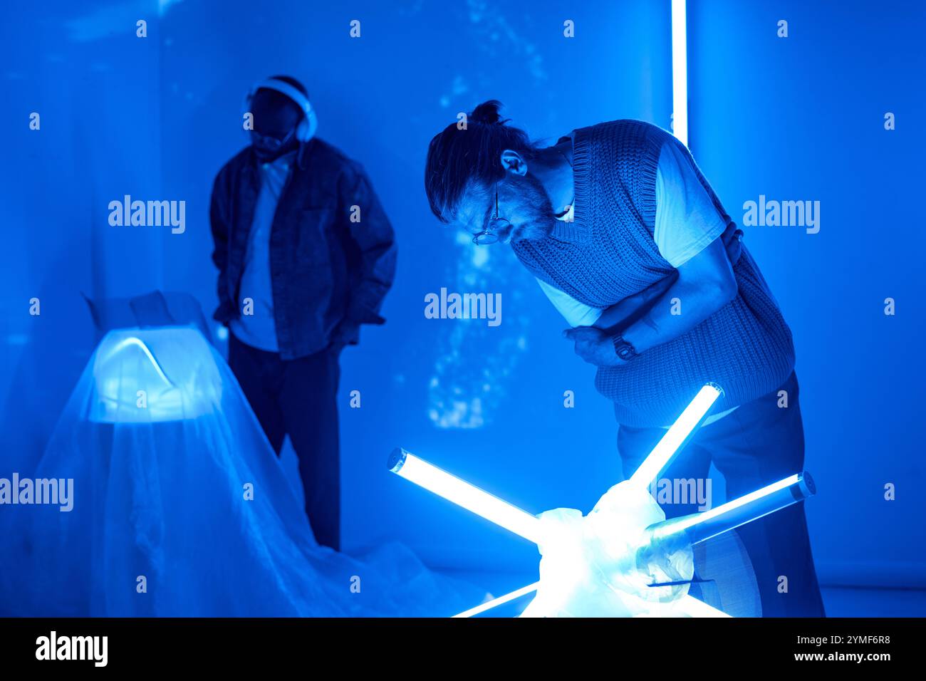Two individuals interacting with advanced technology in a blue ...
