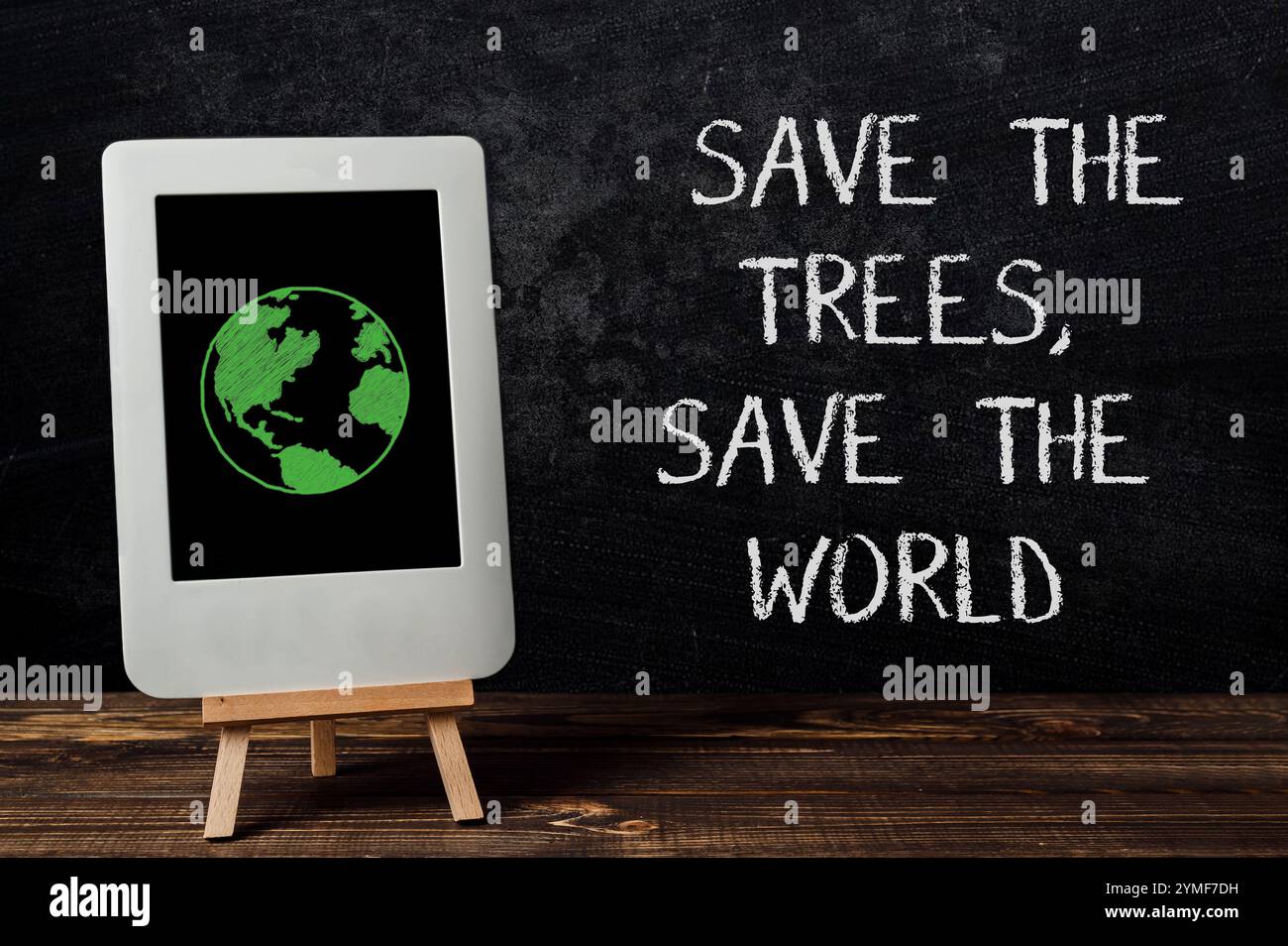 Save the trees, save the world. A tablet with a green planet on it and ...