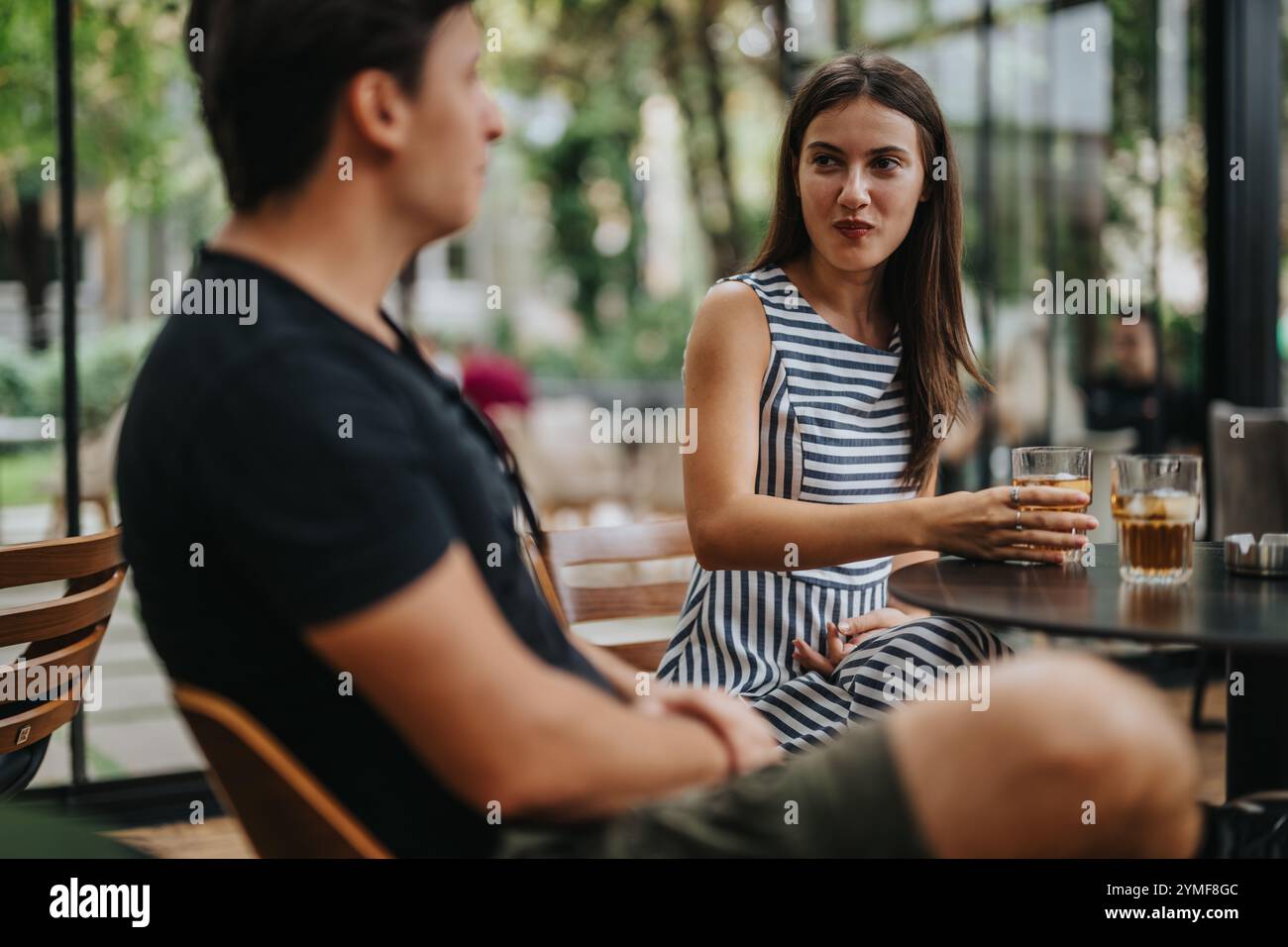 Casual conversation between friends at an outdoor cafe setting Stock ...