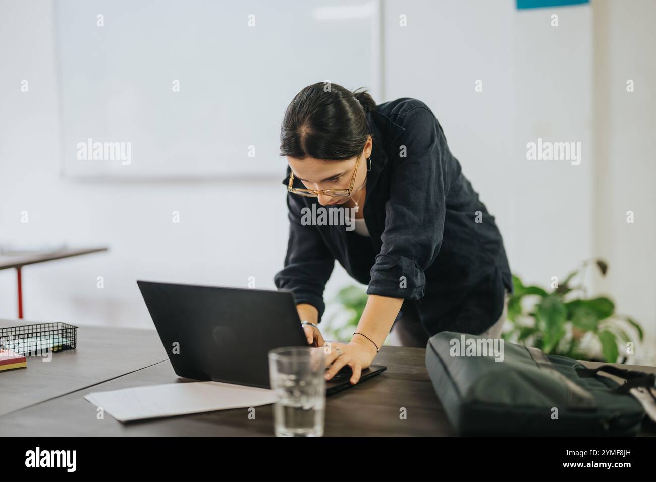 Focused student working on laptop in classroom setting Stock Photo - Alamy