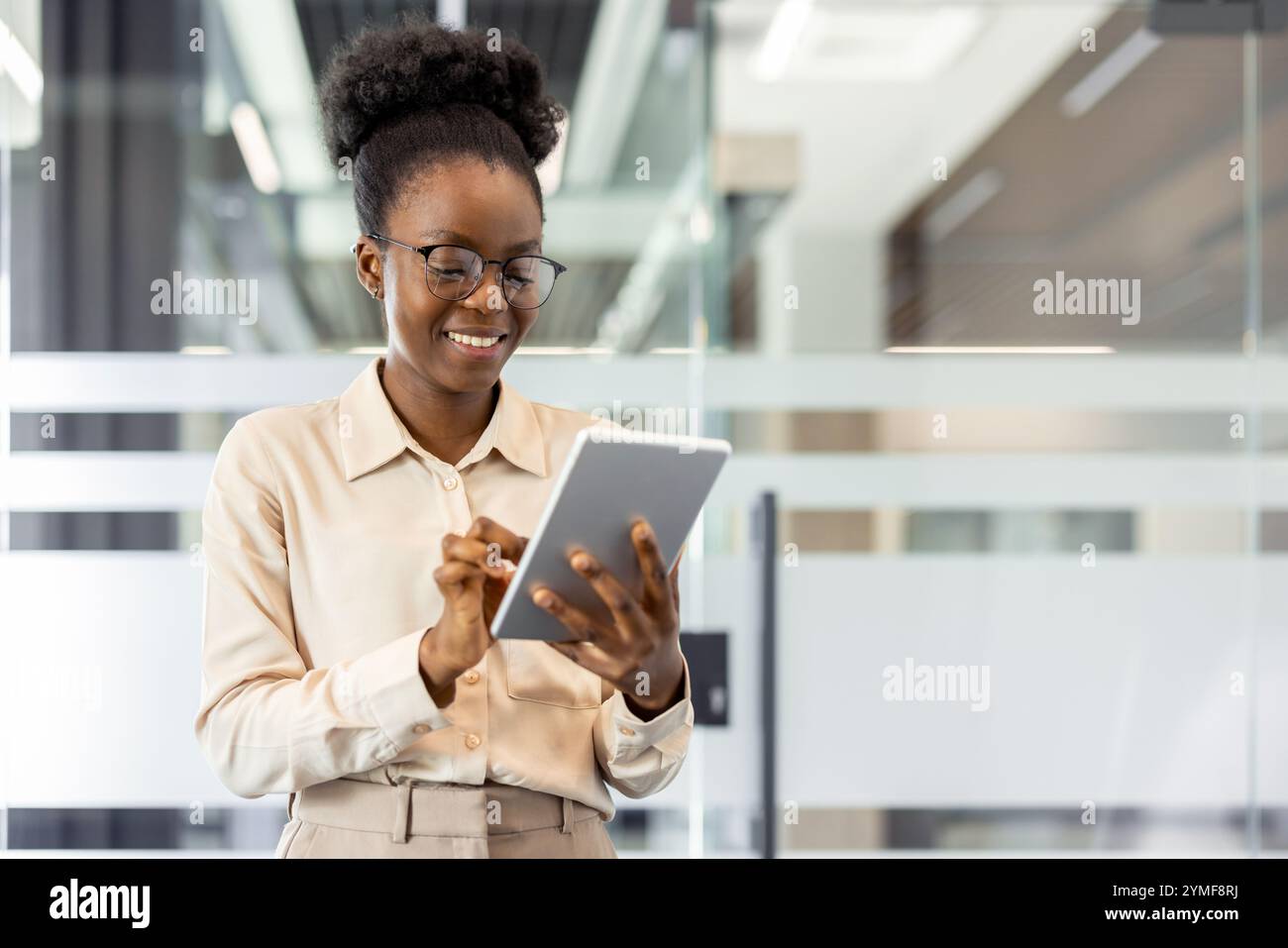 Confident businesswoman uses tablet in modern office. Smiling ...