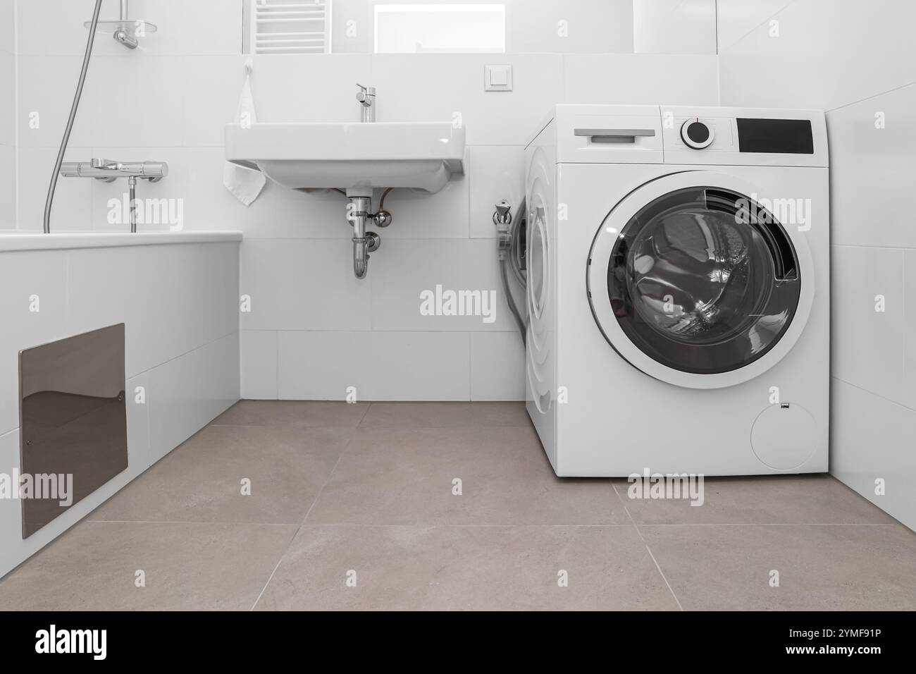 Interior of light bathroom with washing machine and sink Stock Photo ...