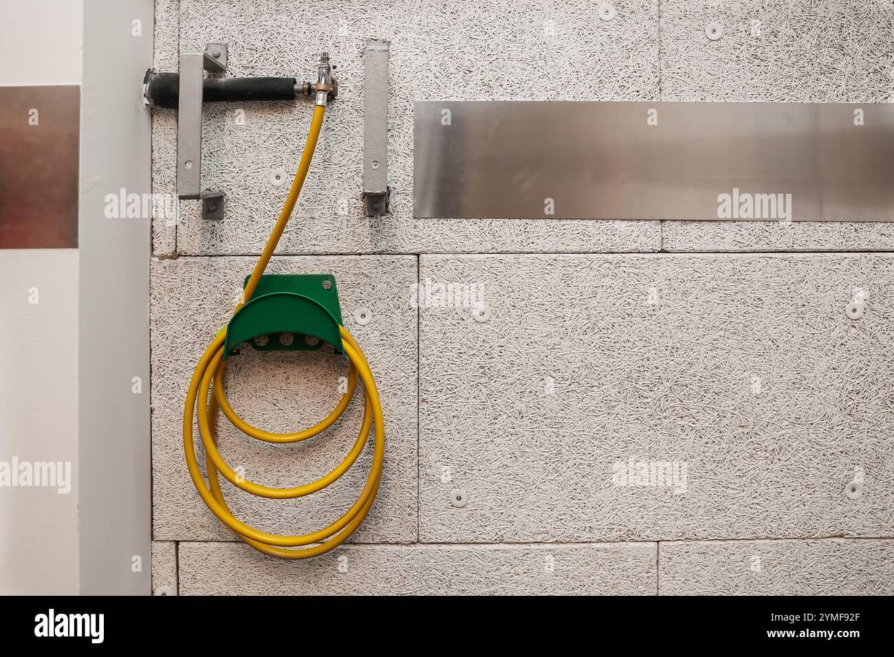 Fire hose hanging on wall in room Stock Photo - Alamy