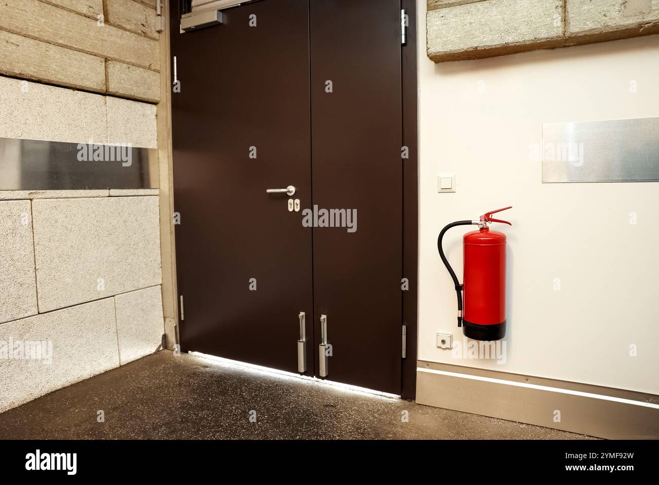 View of fire extinguisher and door in building Stock Photo - Alamy