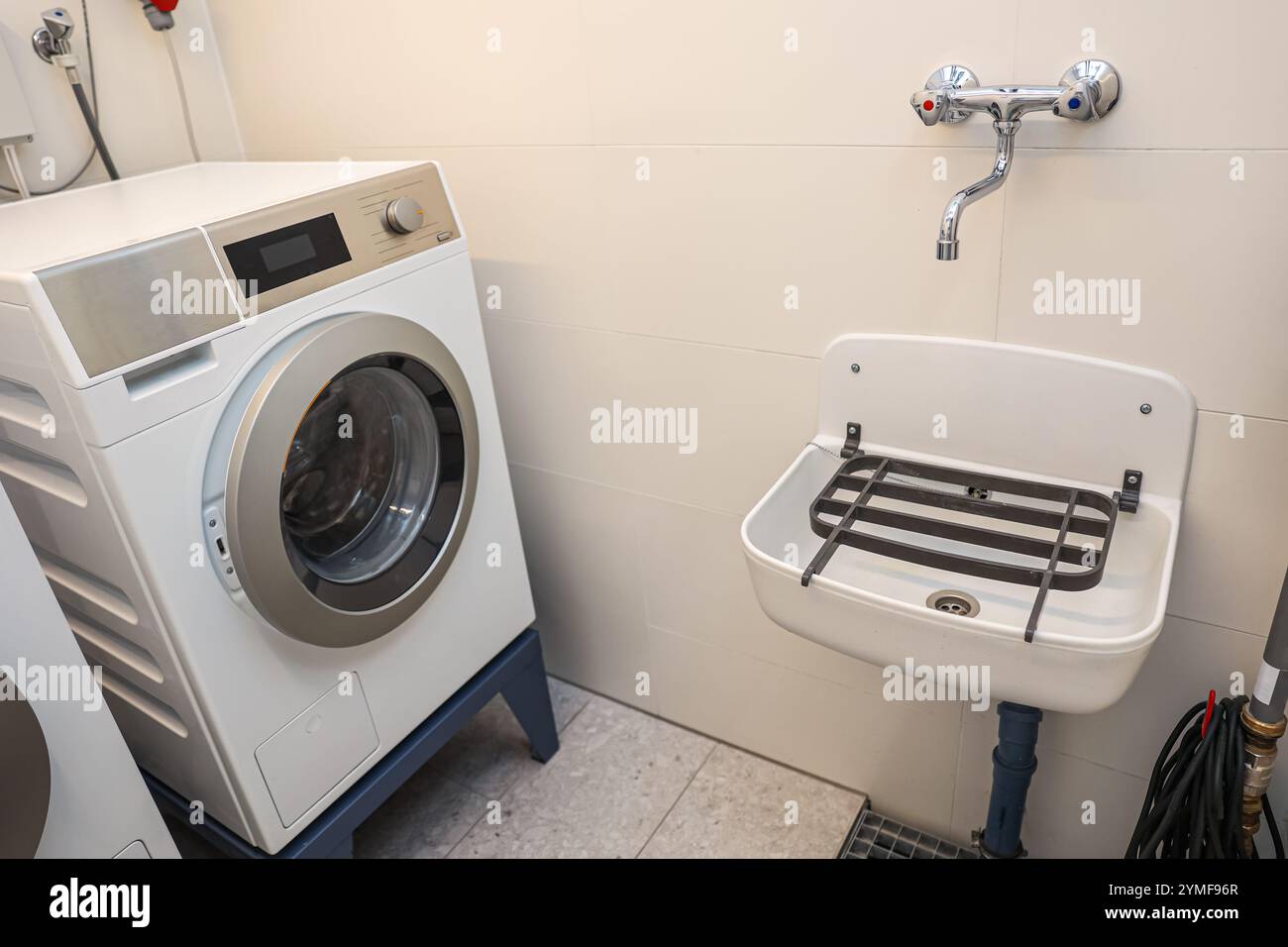 Modern washing machine and sink in laundry room Stock Photo - Alamy