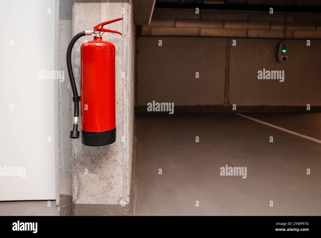 Fire extinguisher hanging on wall in underground parking lot Stock ...
