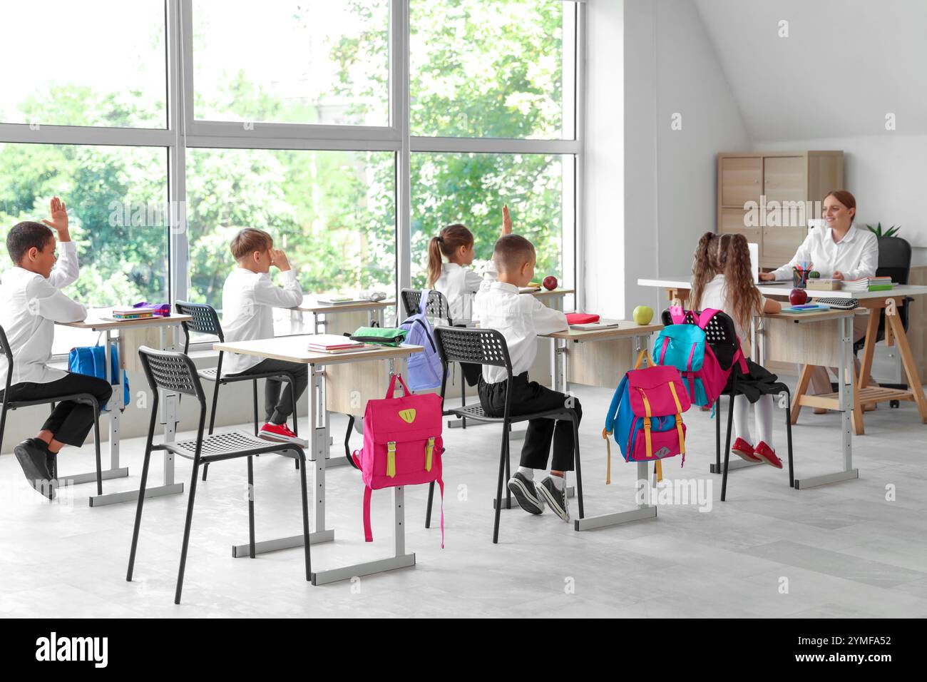 Little pupils having lesson in classroom, back view Stock Photo - Alamy