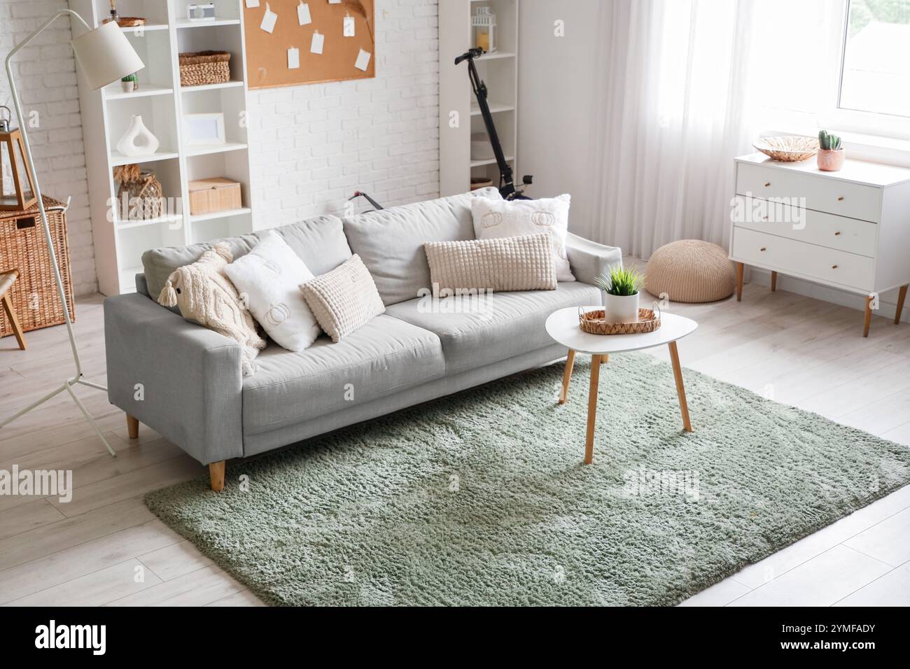 Interior of living room with electric scooter, sofa and shelf units ...