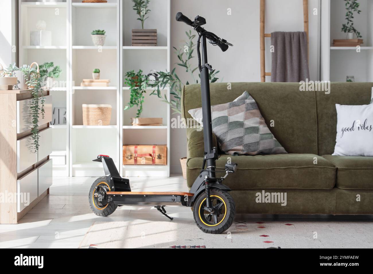 Electric scooter near sofa in living room interior Stock Photo - Alamy