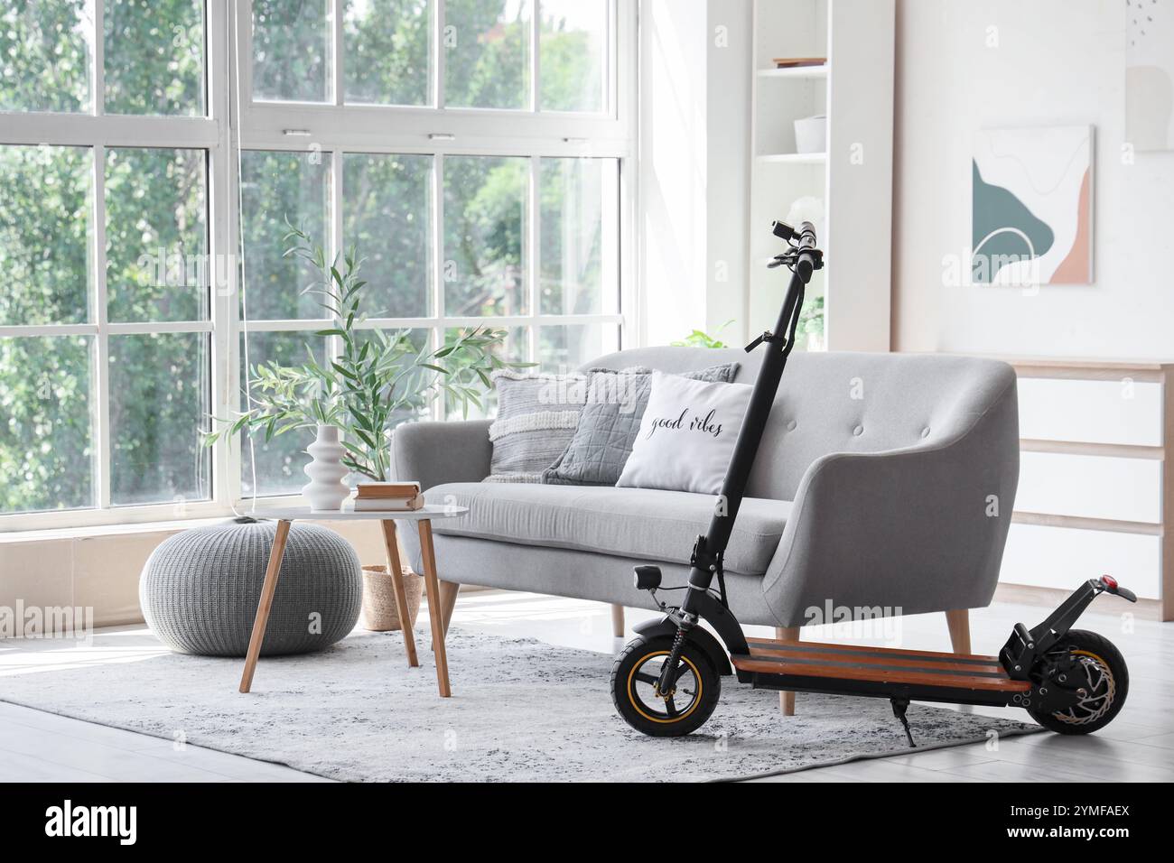 Interior of living room with electric scooter, sofa and table Stock ...