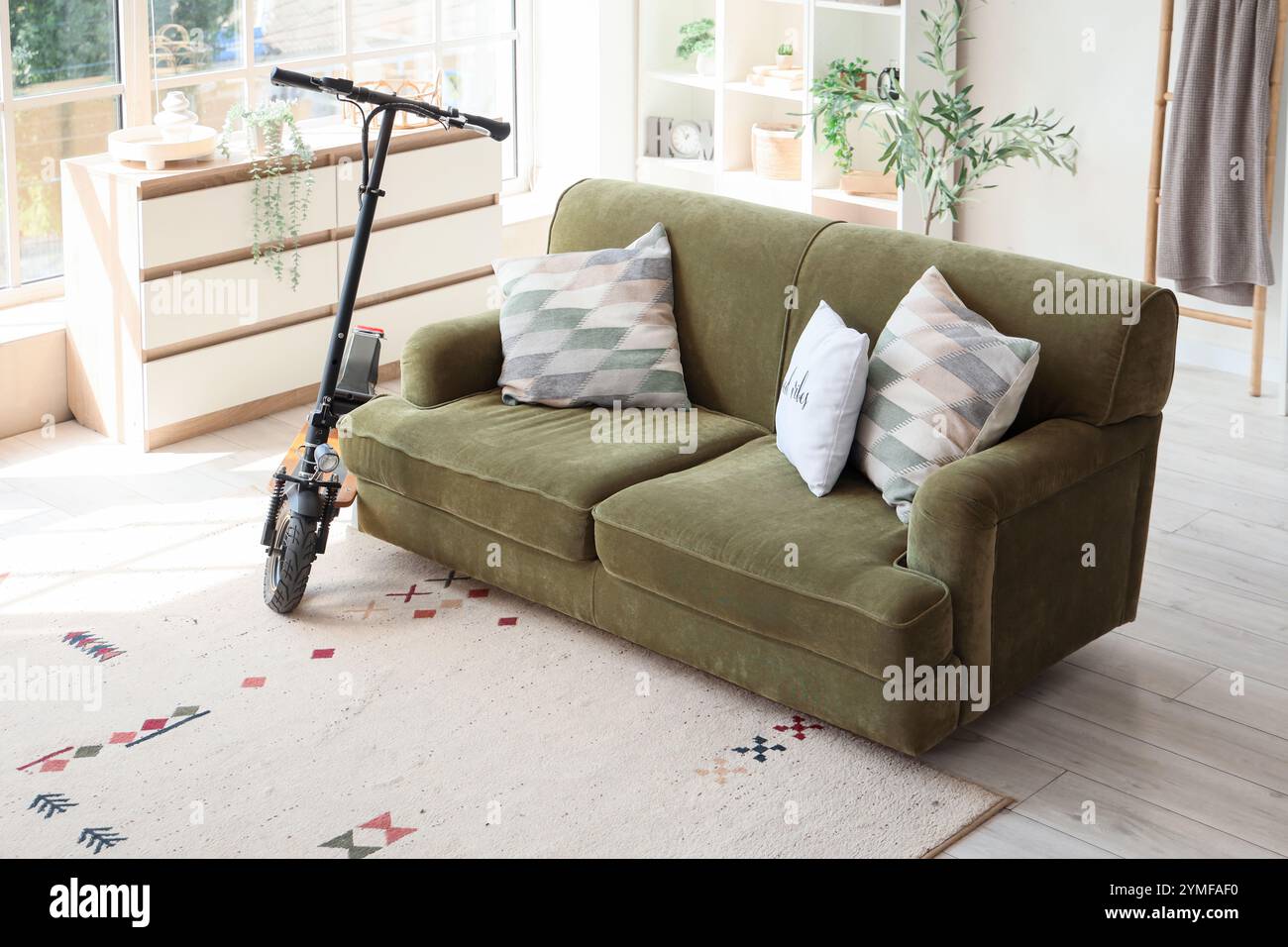 Interior of living room with electric scooter, sofa and drawers Stock ...