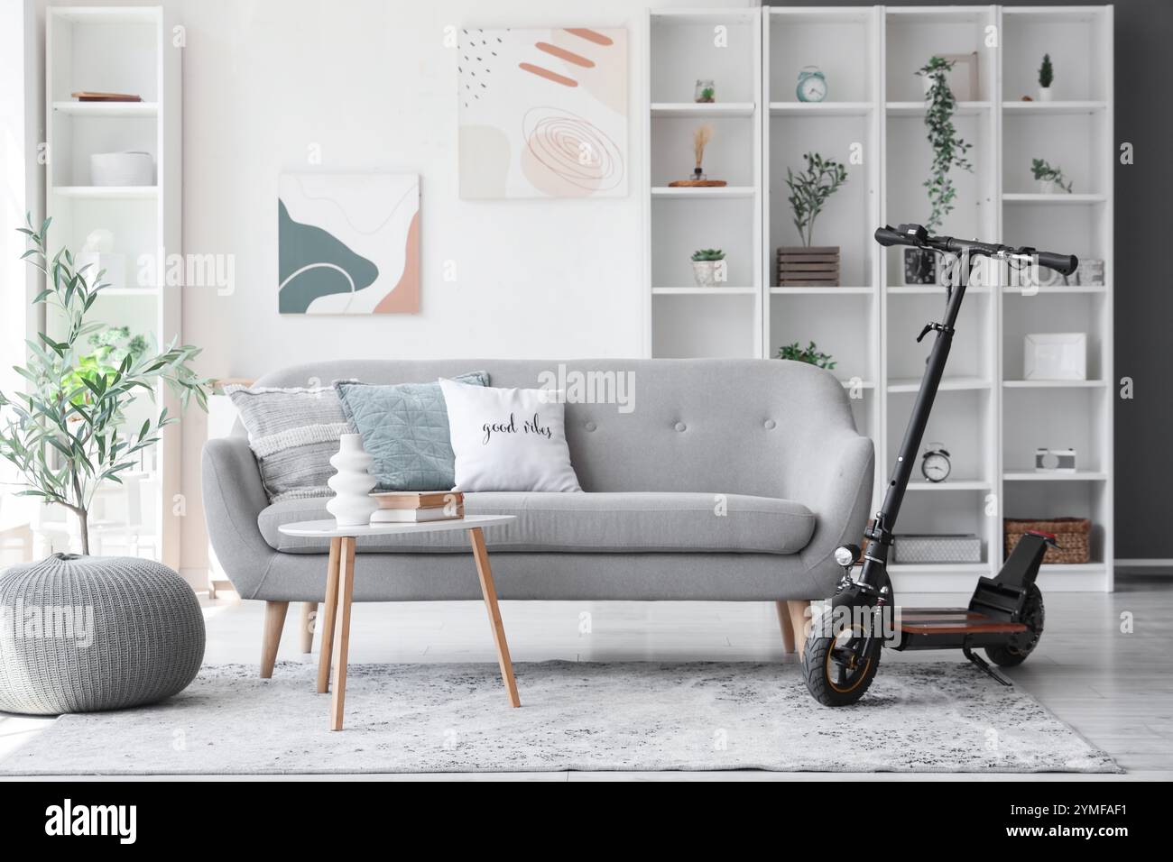 Interior of living room with electric scooter, sofa and shelf units ...