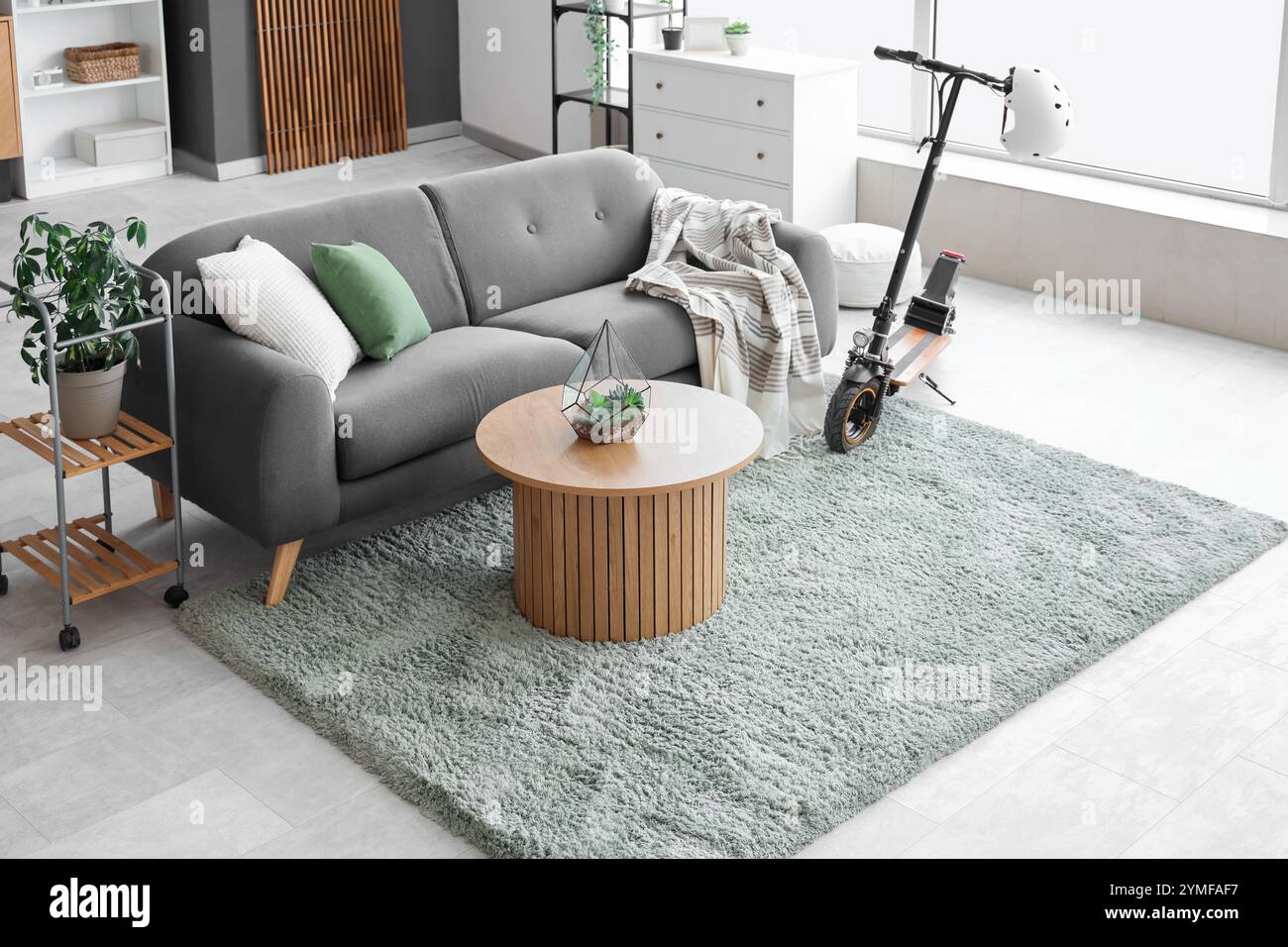 Interior of living room with electric scooter, sofa and table Stock ...