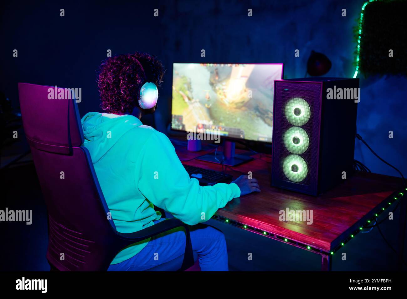 Photo of gamer nice young male back view play computer strategy game ...
