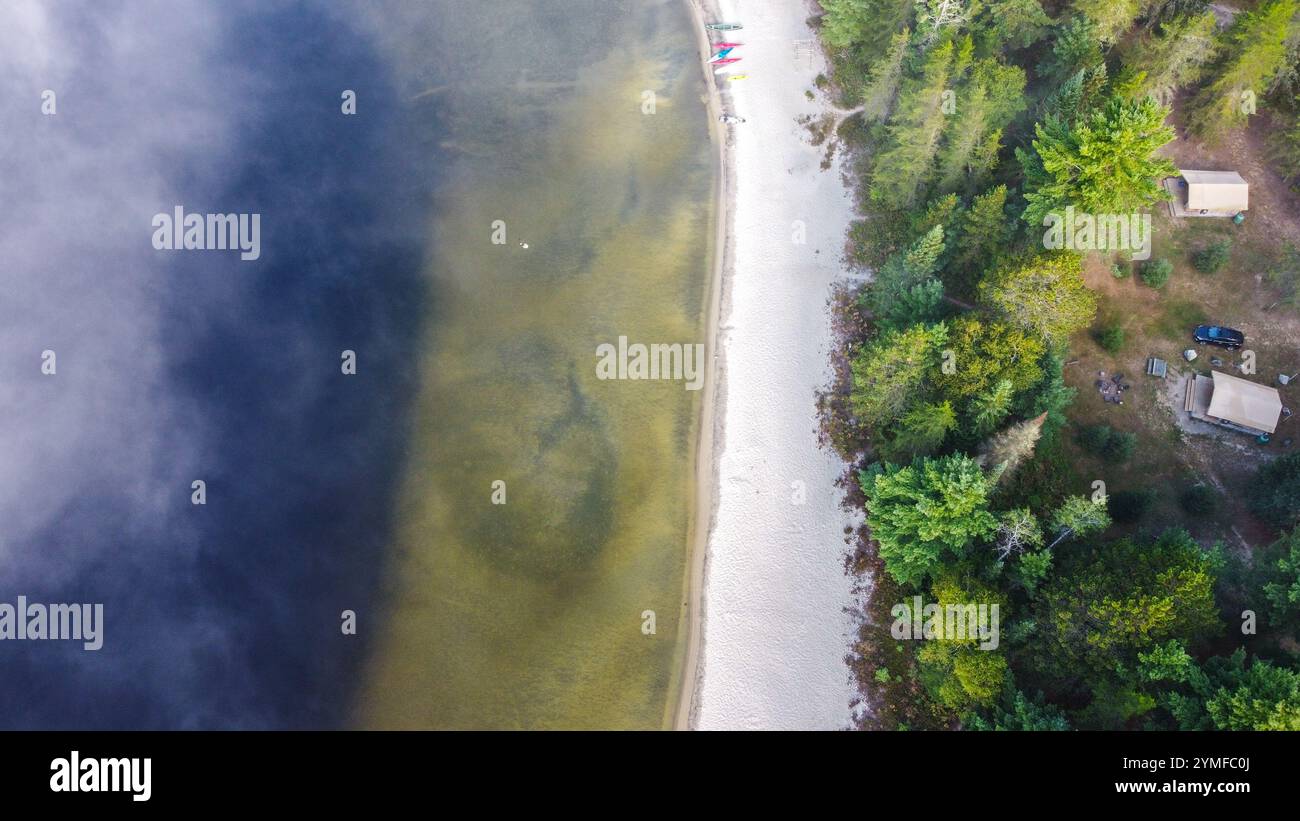 The image shows a beautiful lakeside campsite in the morning. The ...