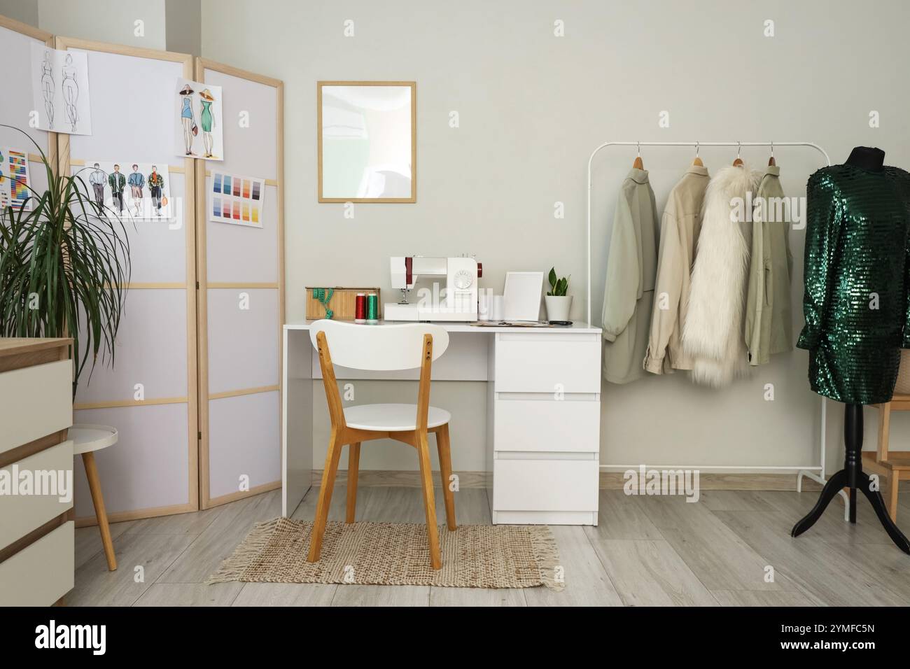 Interior of atelier with tailor's workplace, folding screen and clothes ...